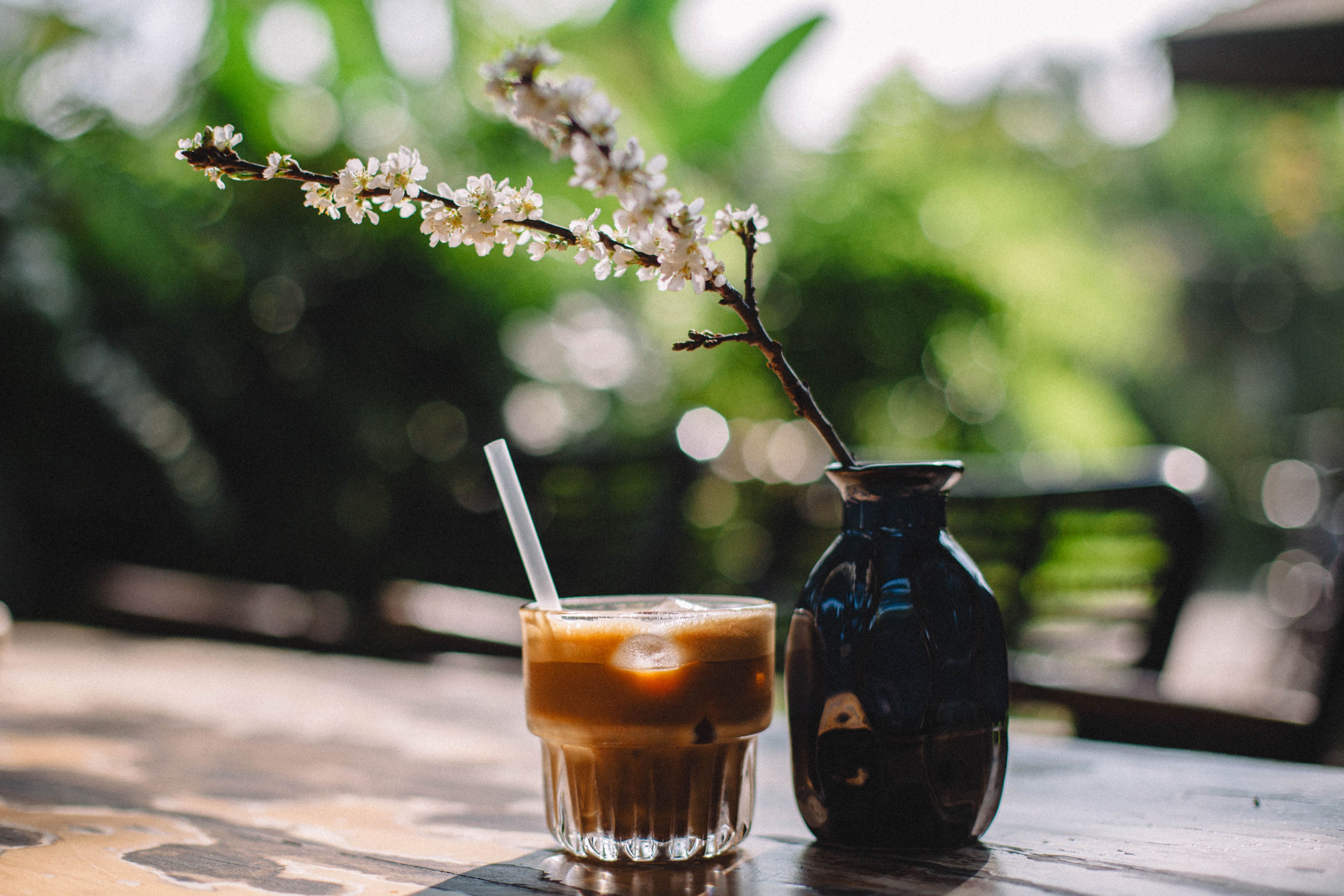 Refreshing Iced Coffee with Bloom Vase Outdoors · Free Stock Photo