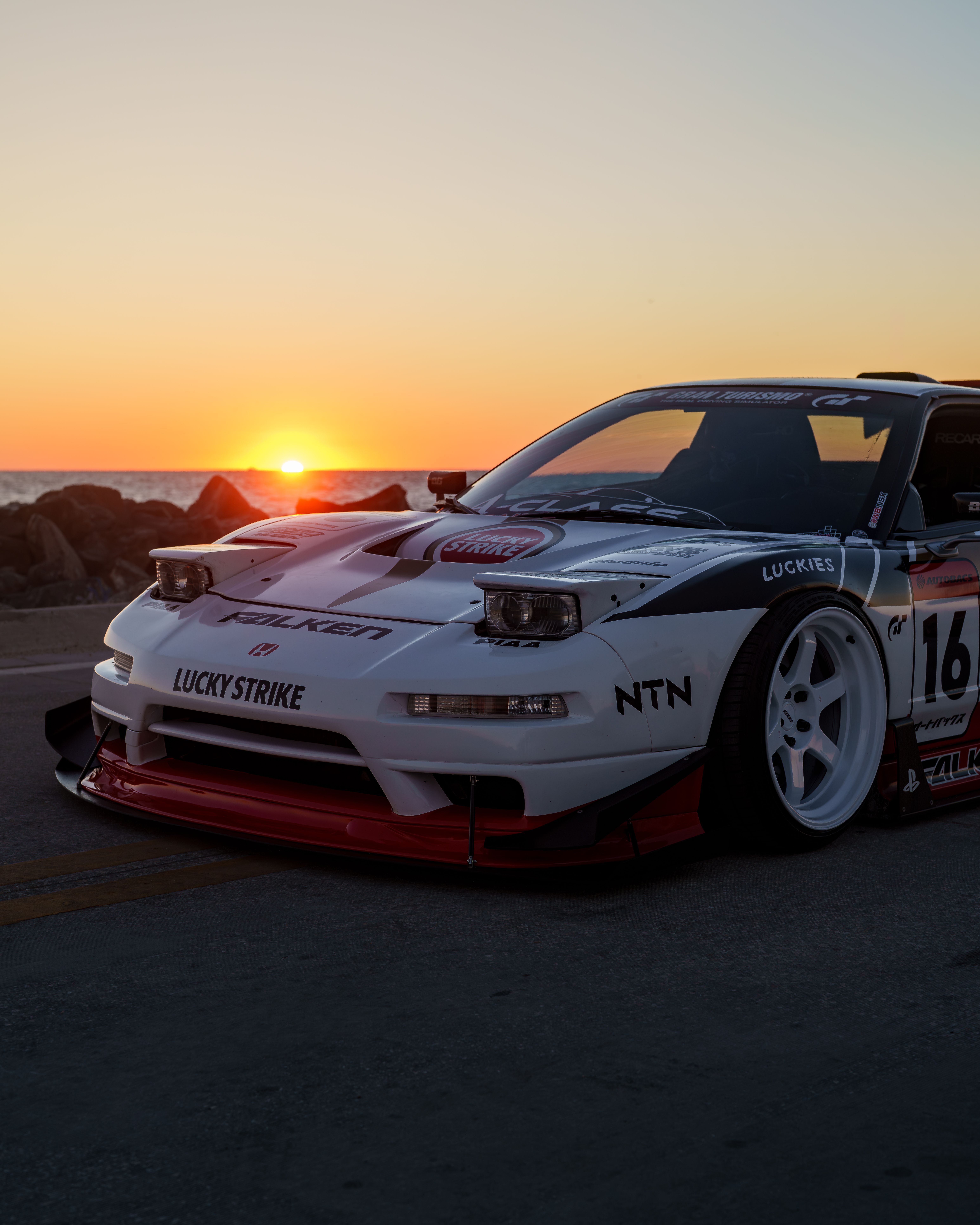 Race Car at Sunset on Coastal Road · Free Stock Photo