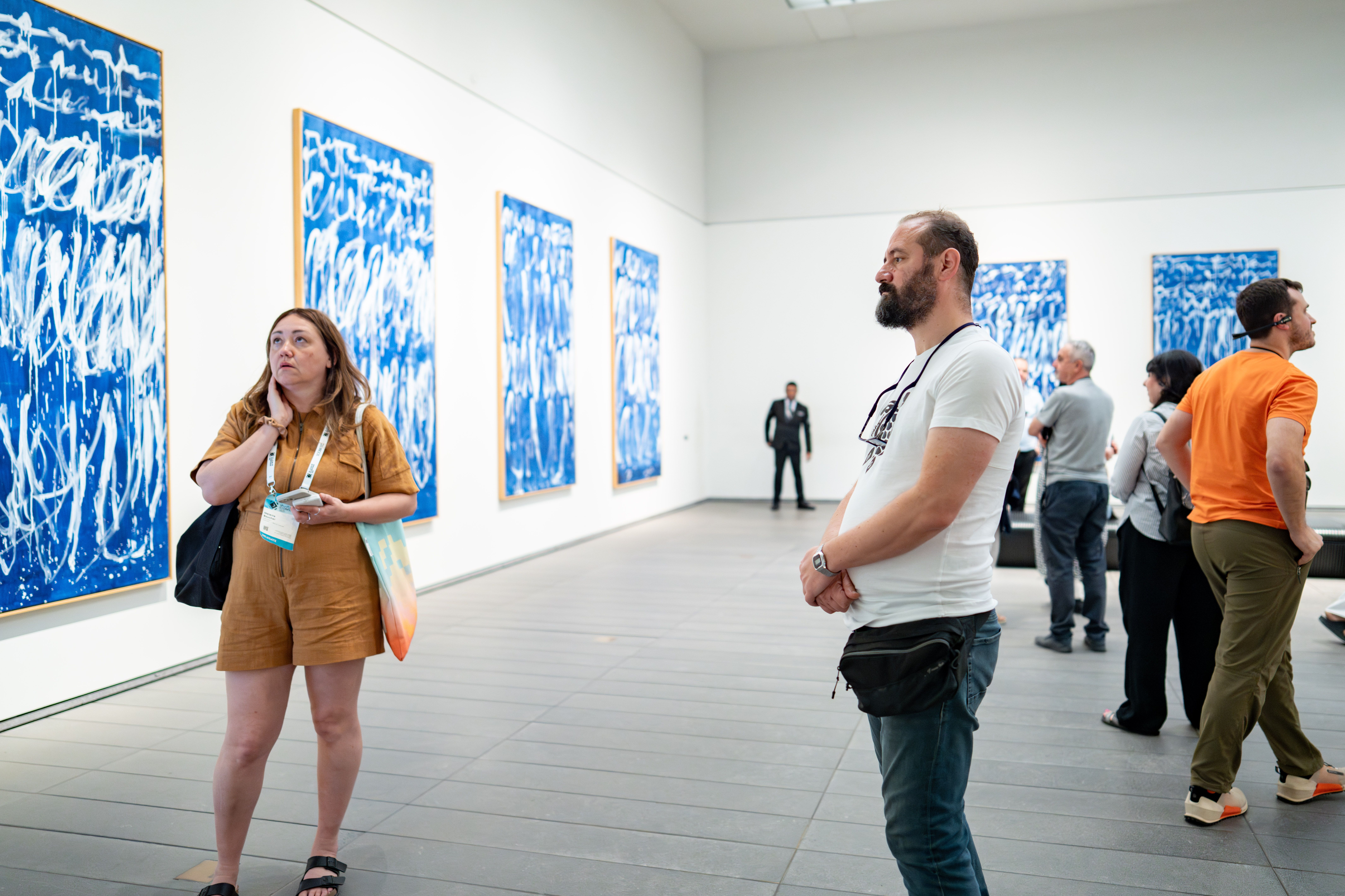 Visitantes De La Galería De Arte Observando Pinturas Abstractas Azules ...