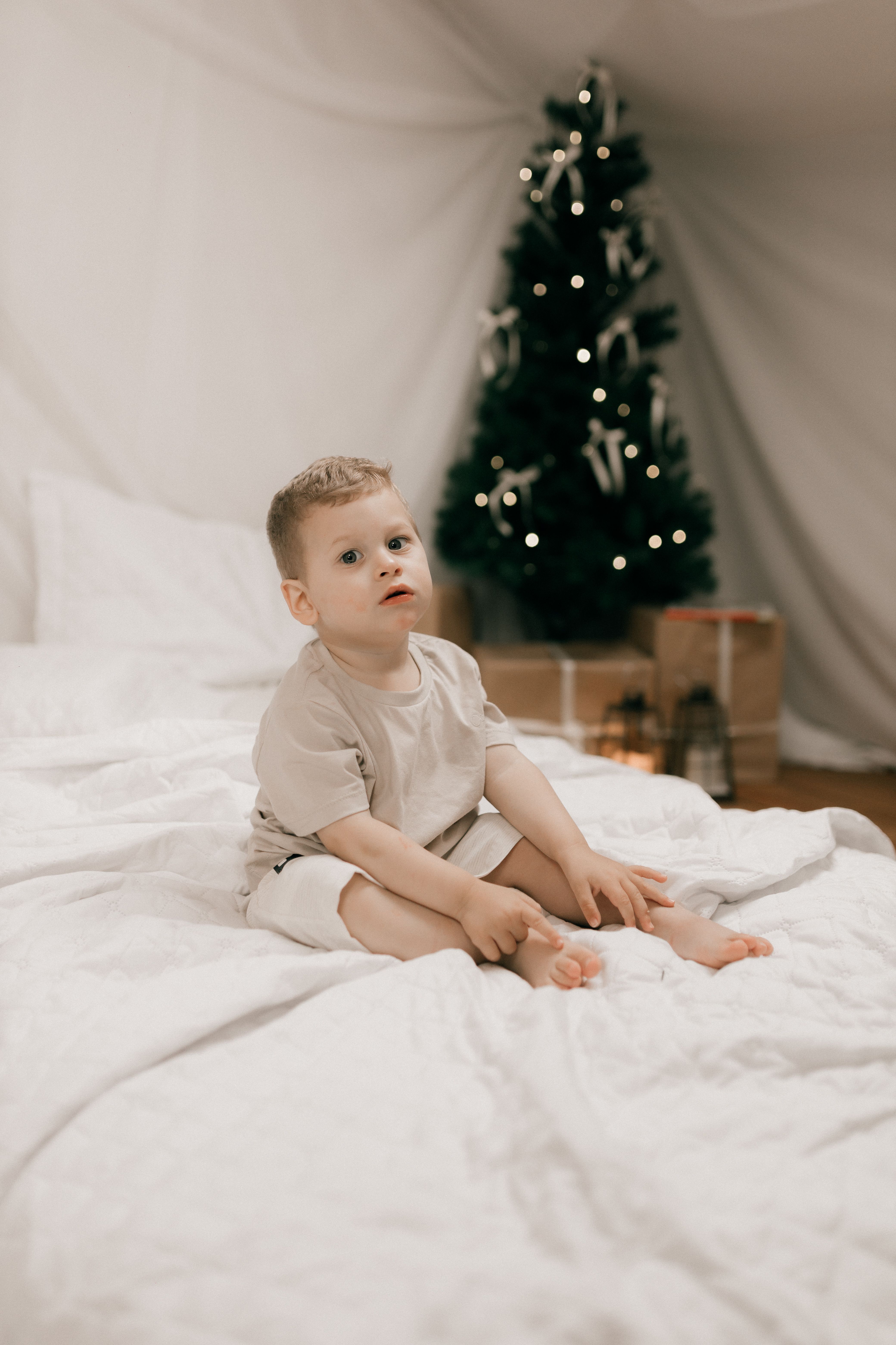 Adorable Child Sitting by Christmas Tree · Free Stock Photo