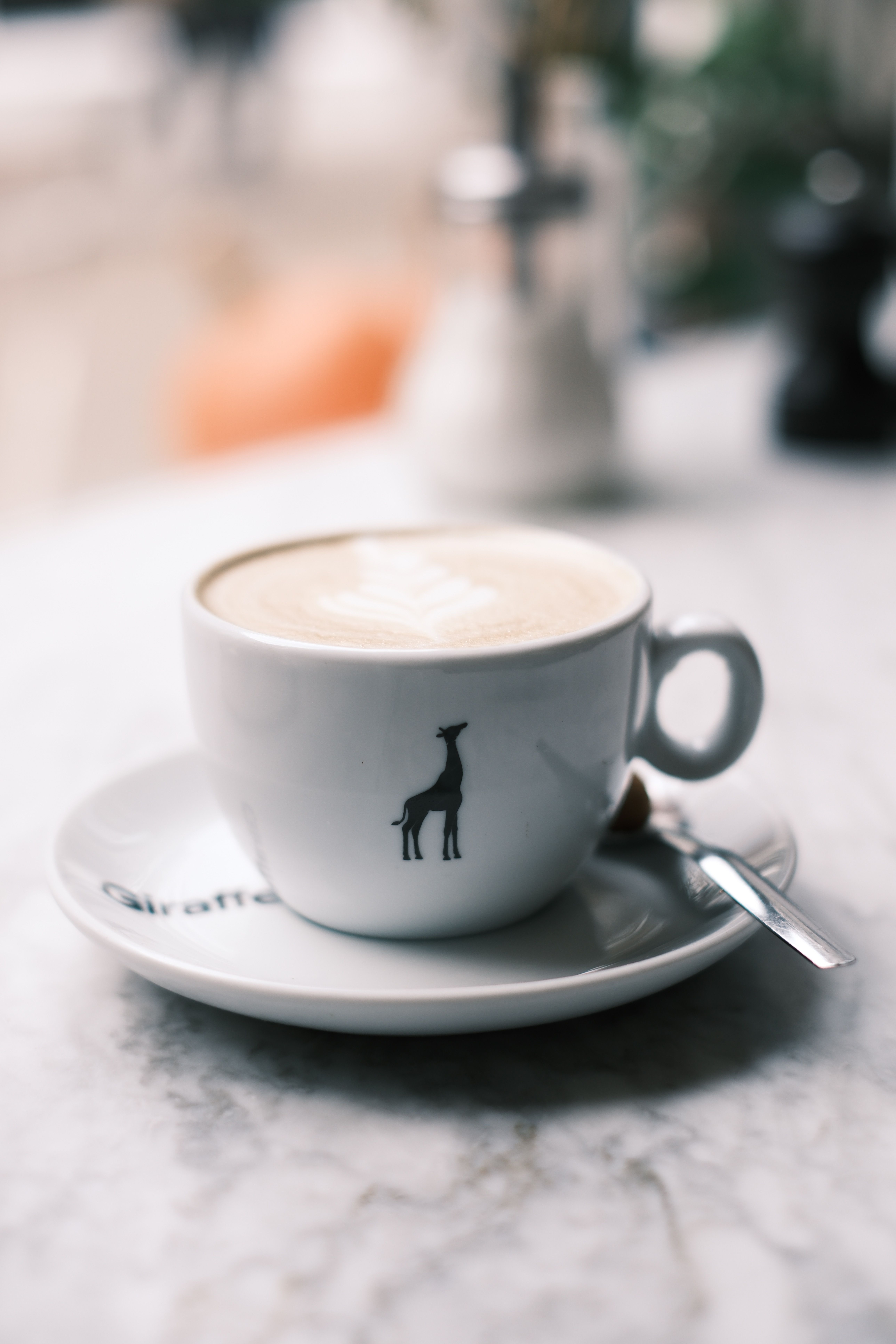 Elegant Coffee Cup with Giraffe Logo · Free Stock Photo