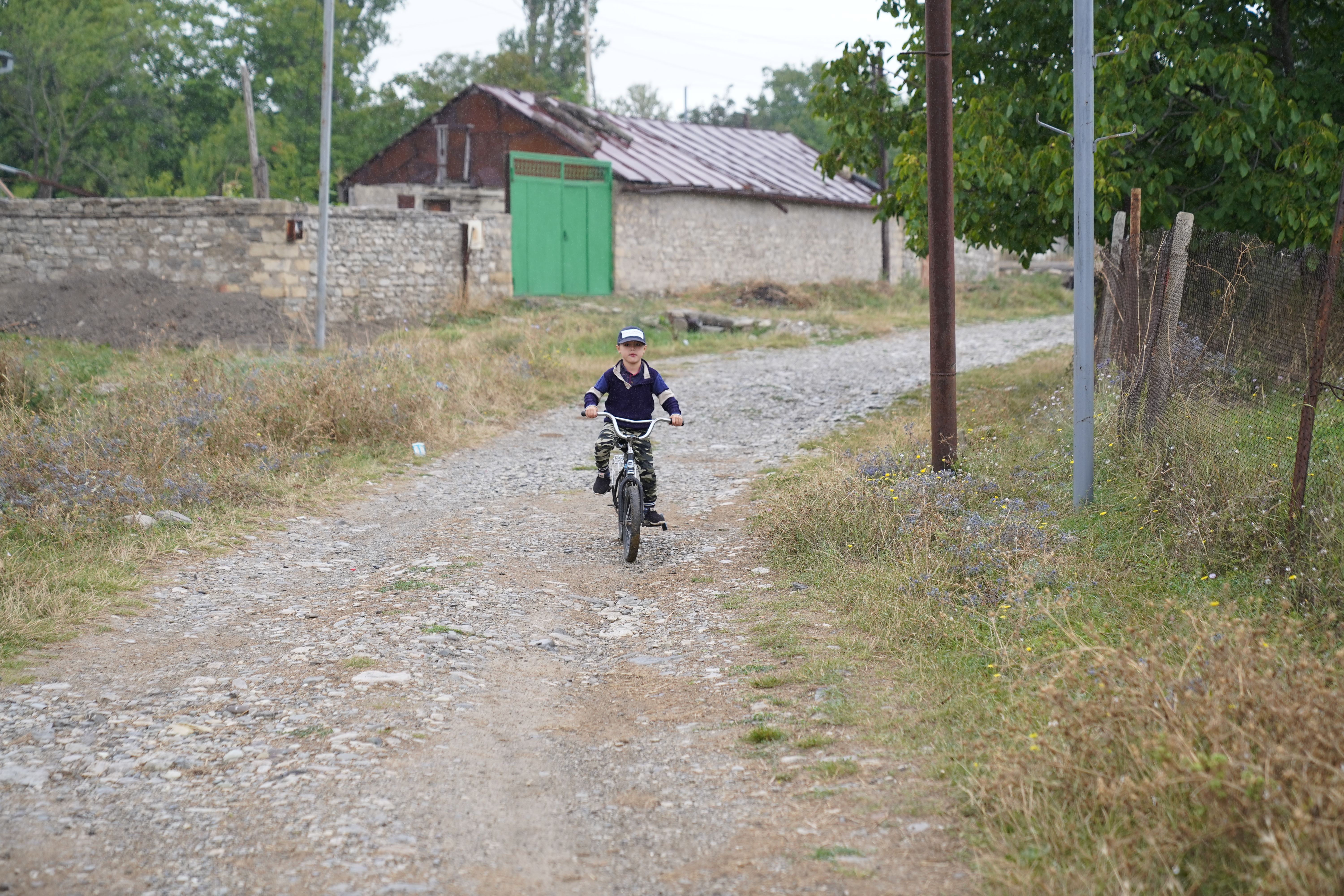 Child Biking on Country Road Near a Village · Free Stock Photo