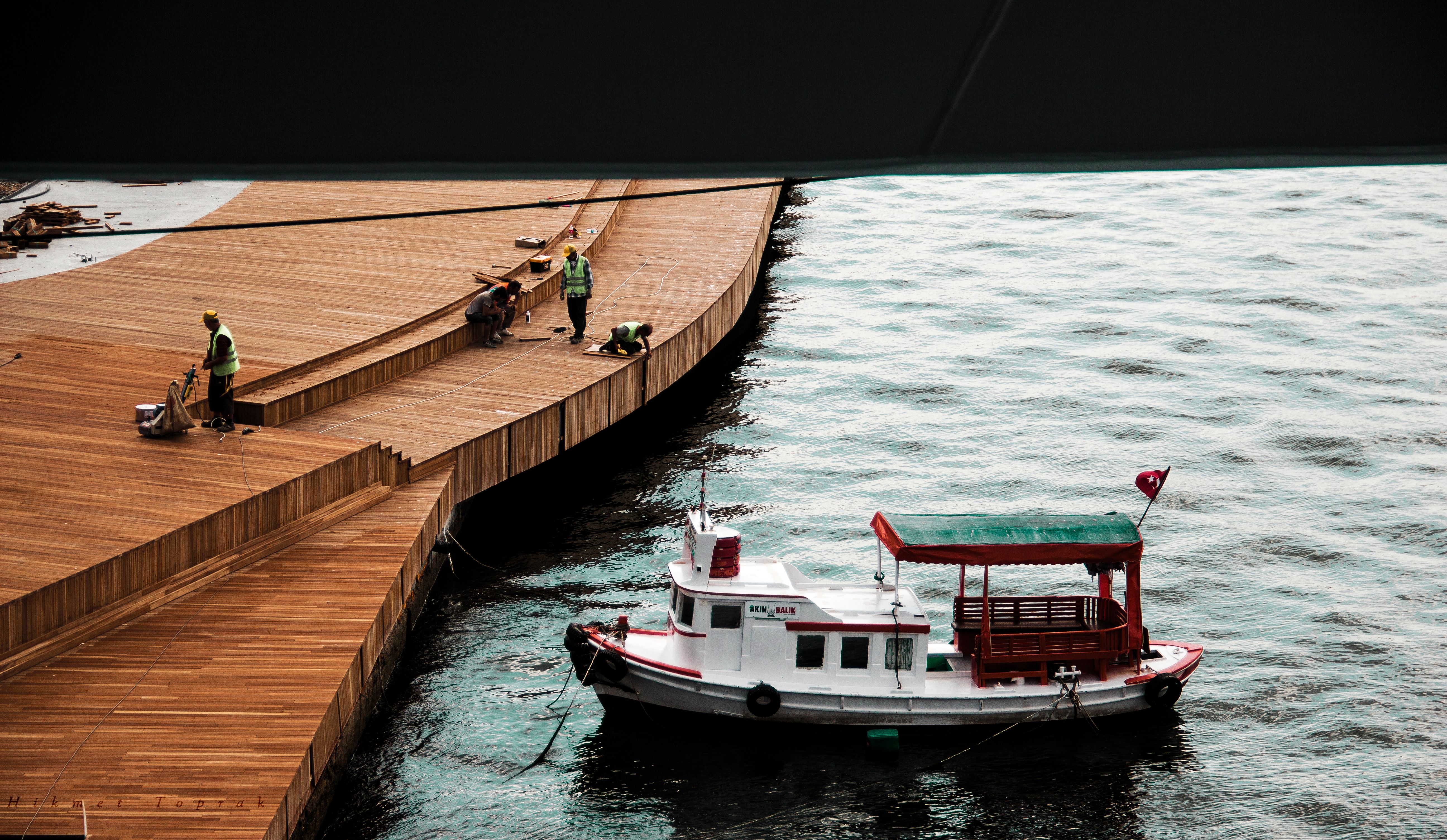 Workers on Wooden Dock with Boat Nearby · Free Stock Photo