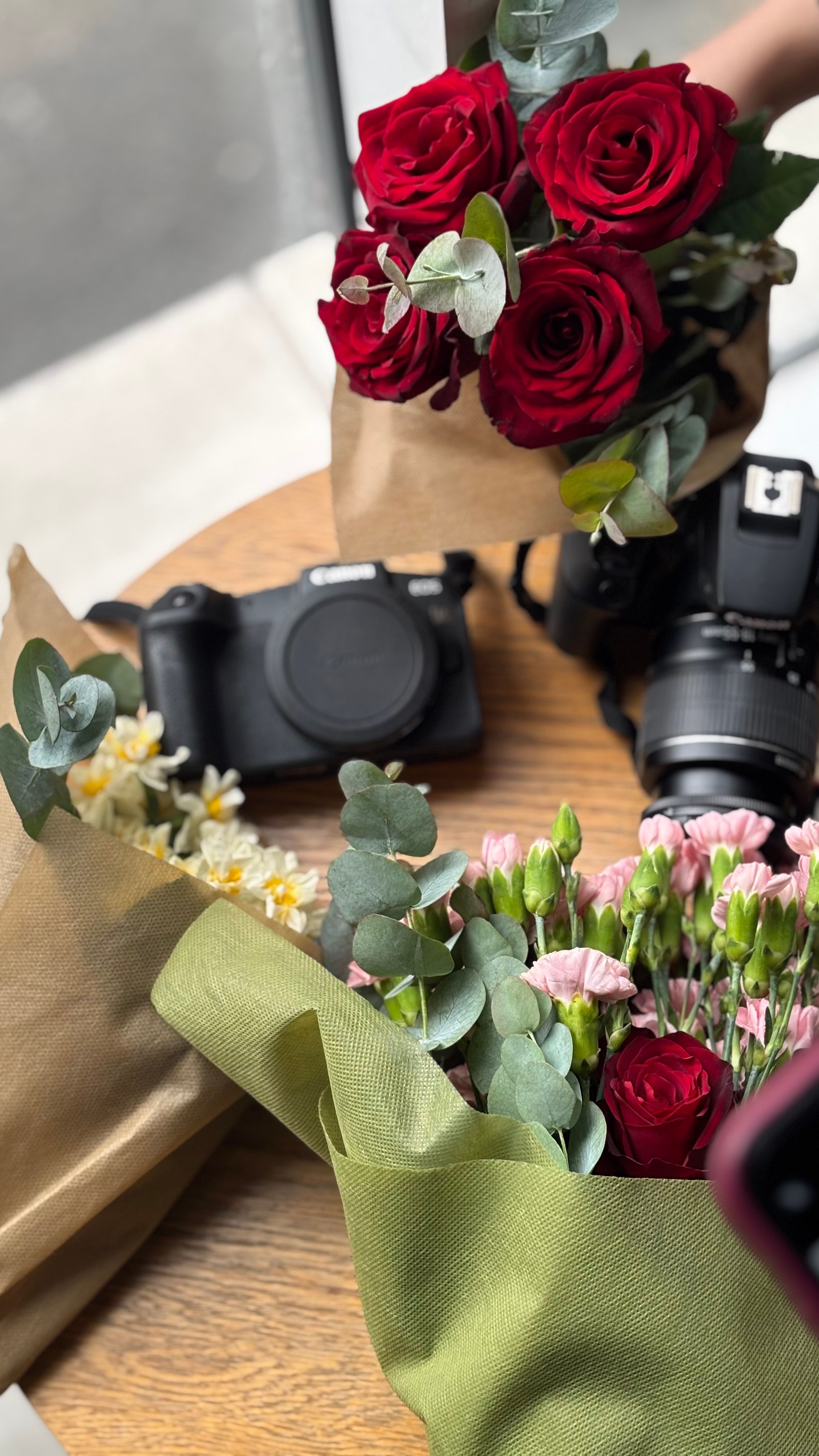 Floral Bouquets and Cameras on Wooden Table · Free Stock Photo
