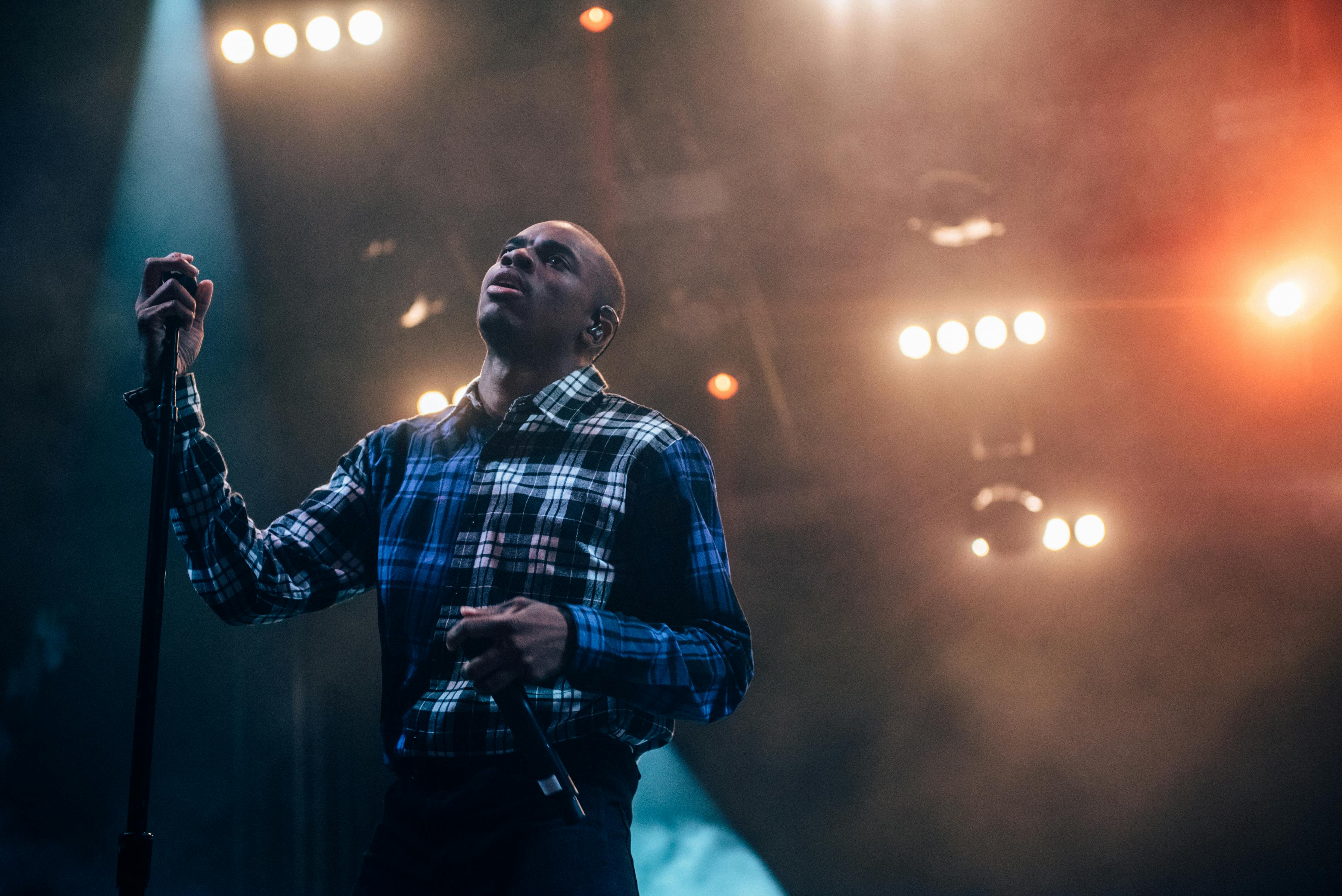 Man Holding Microphone on Stage · Free Stock Photo
