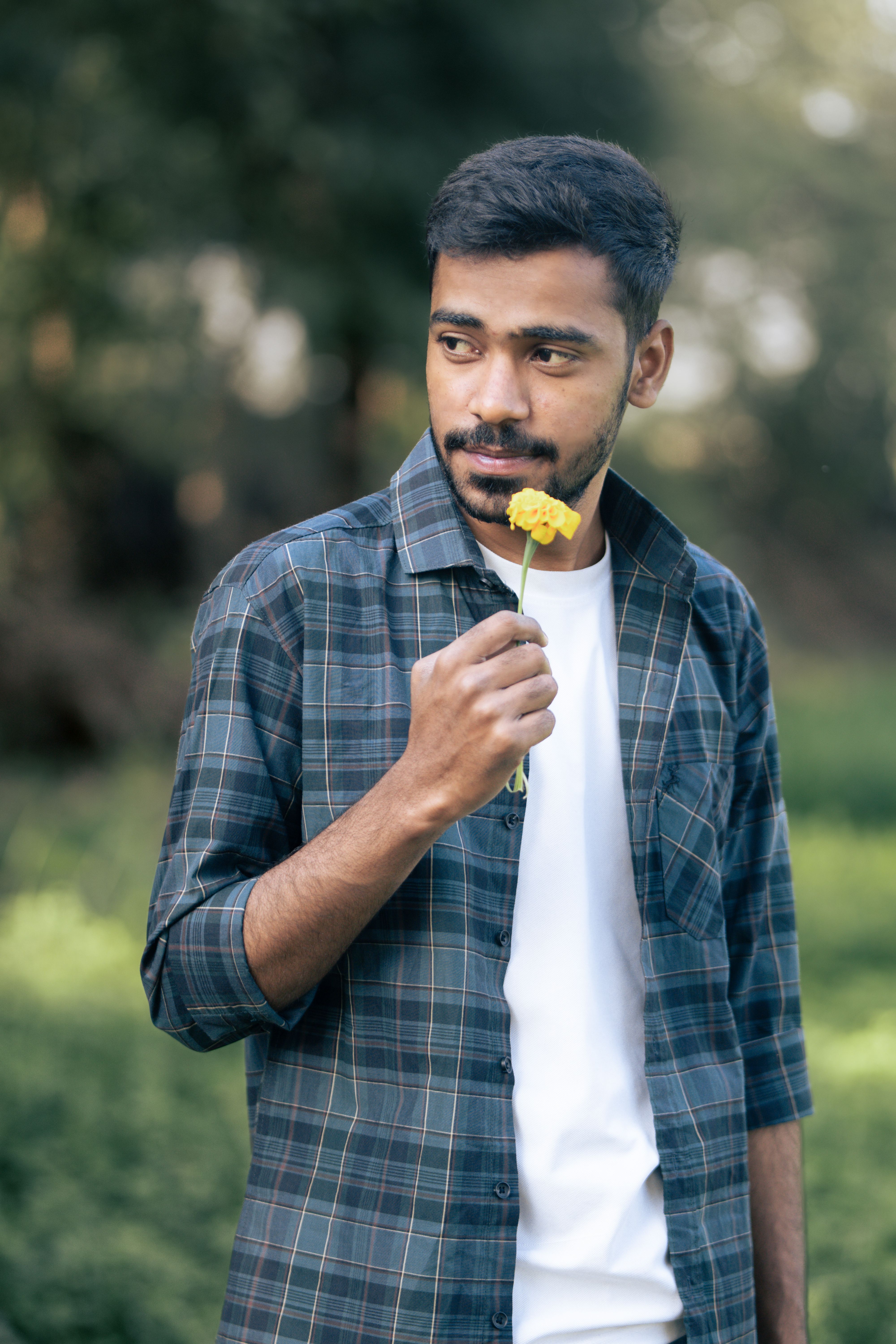 Young Man Holding Yellow Flower Outdoors · Free Stock Photo