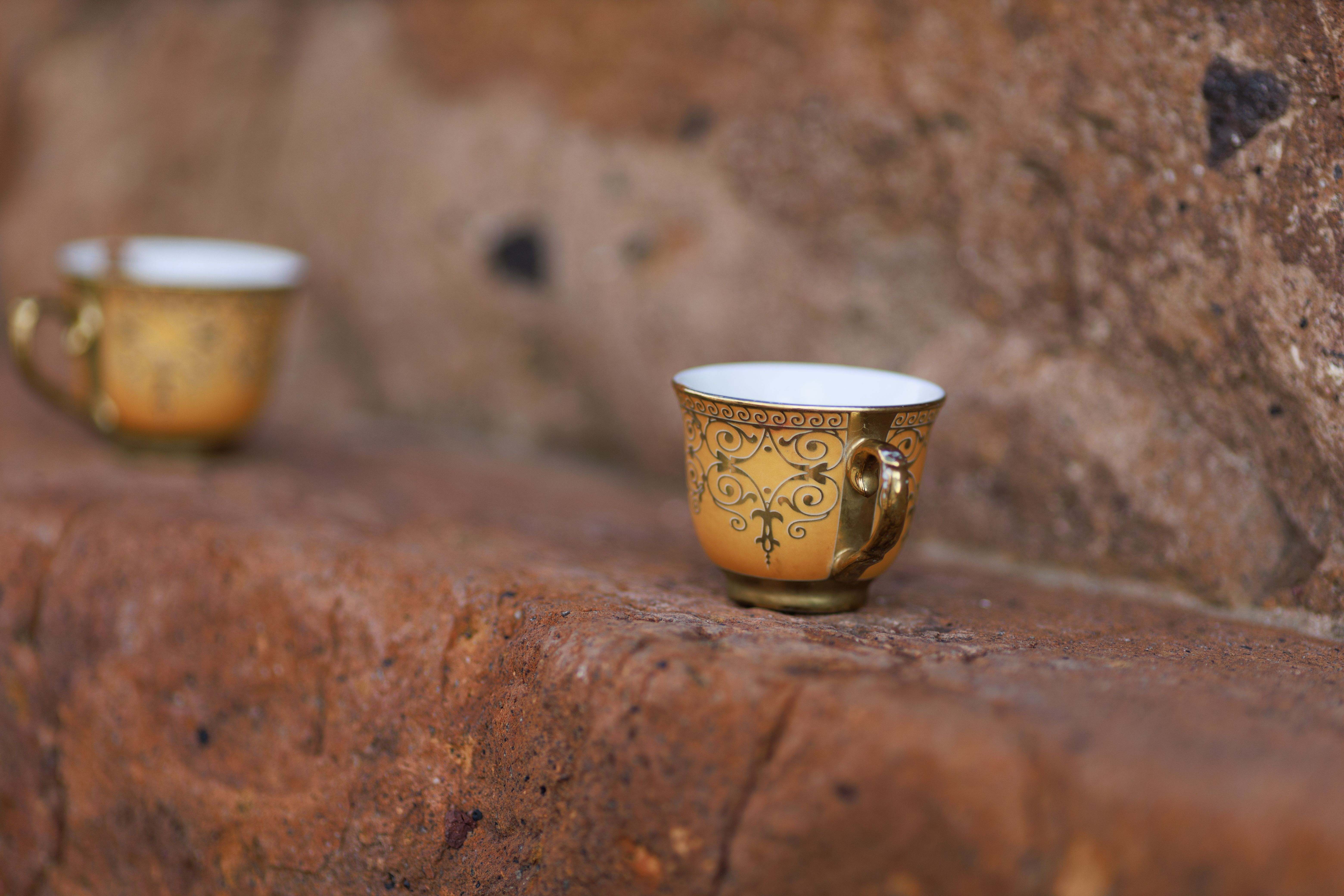 Vintage Golden Teacup on Rustic Surface · Free Stock Photo