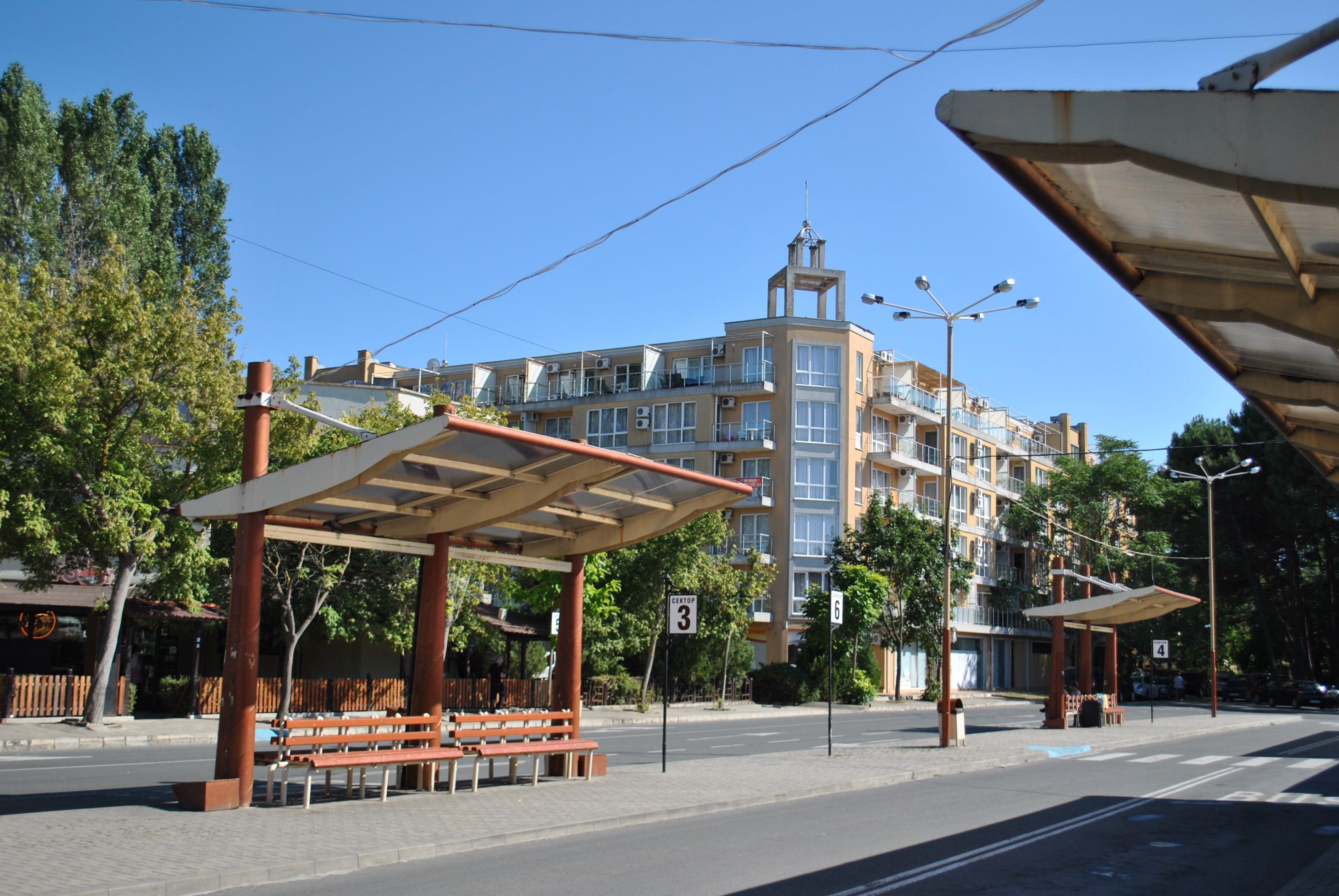 Urban Bus Stop with Modern Apartment Building · Free Stock Photo