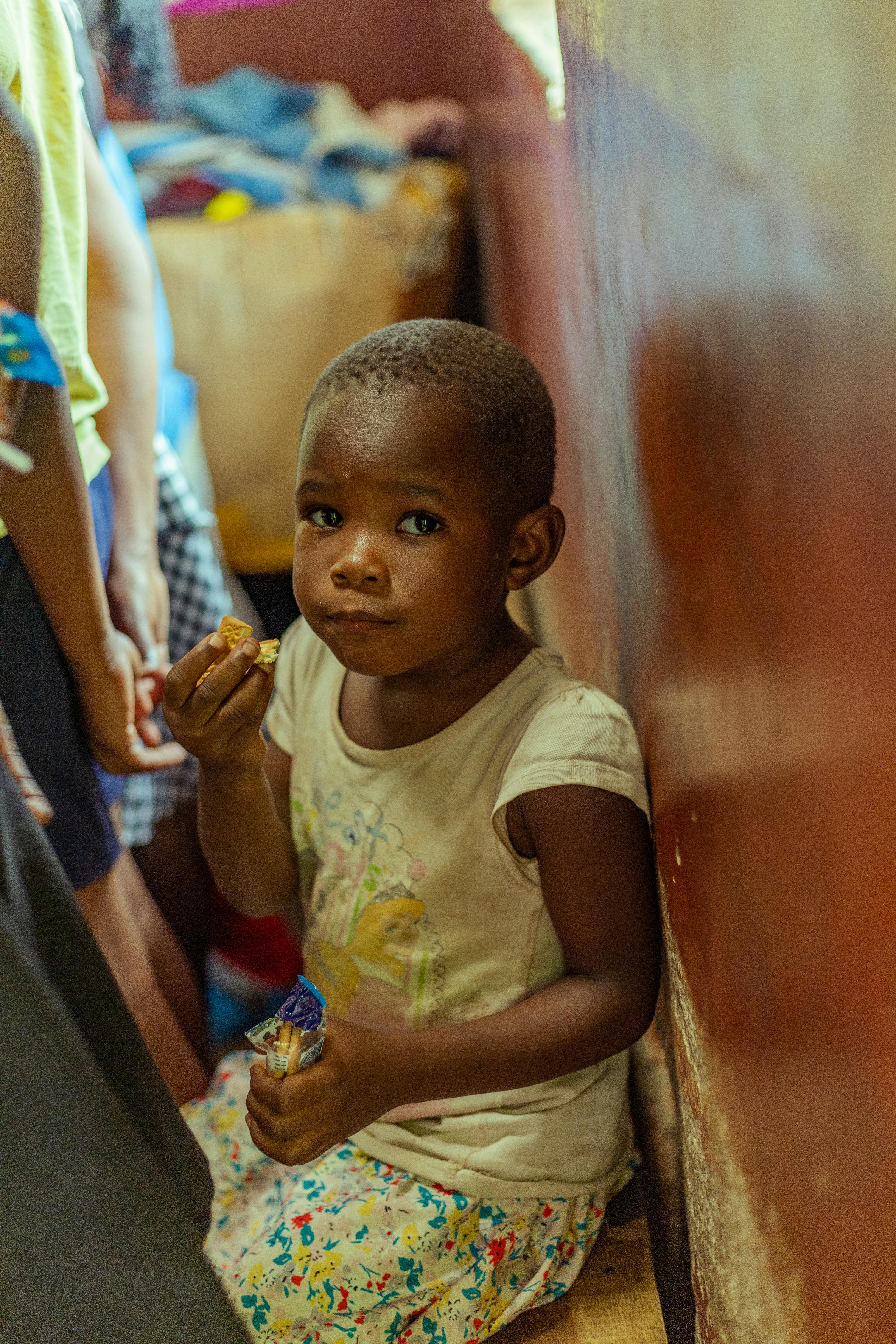 Young Child Eating Biscuit in Indoor Setting · Free Stock Photo