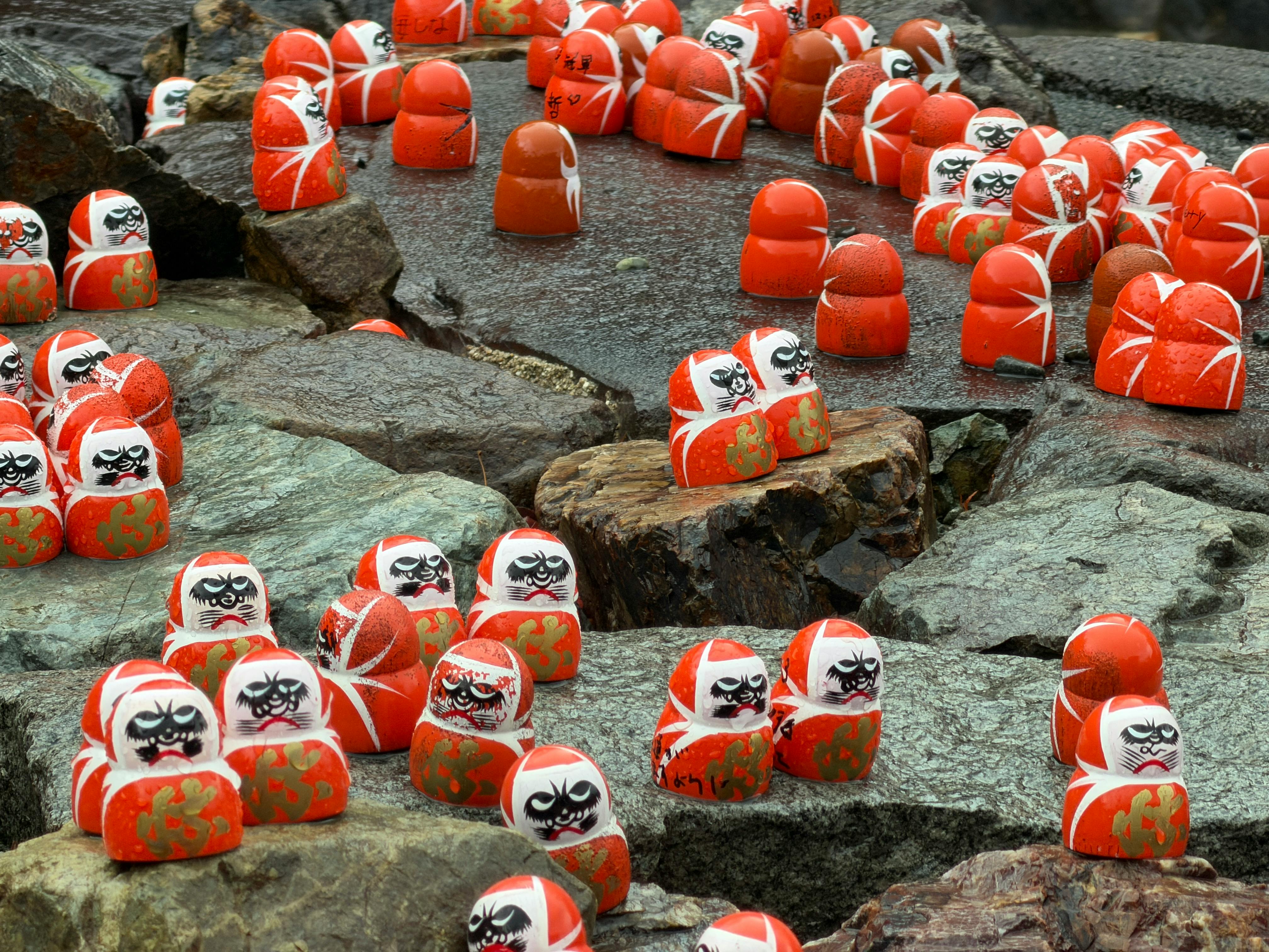 Muñecas Daruma Coloridas En Terreno Rocoso · Foto de stock gratuita