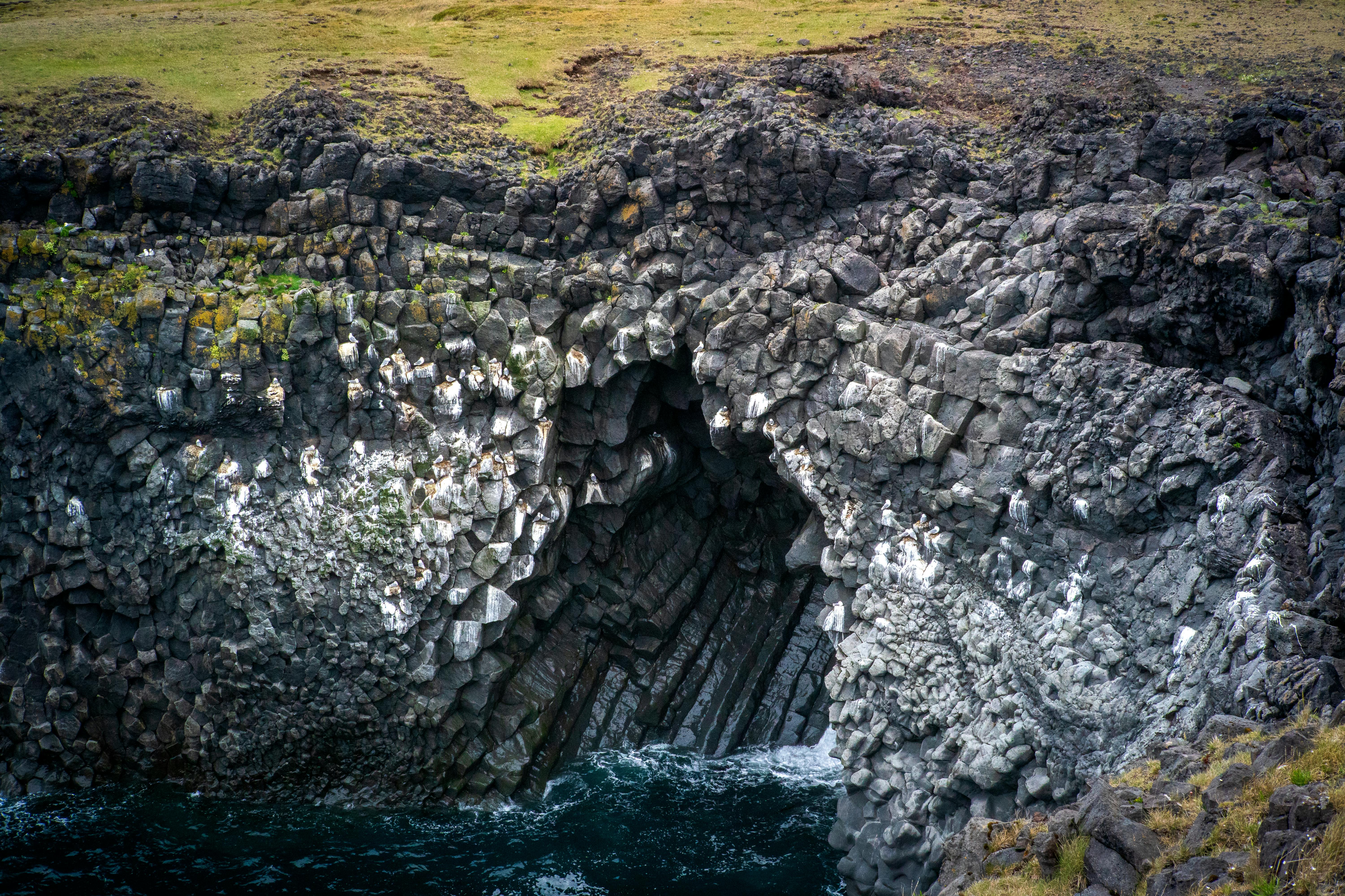 Dramatic view of basalt rock formations in Iceland with crashing waves.