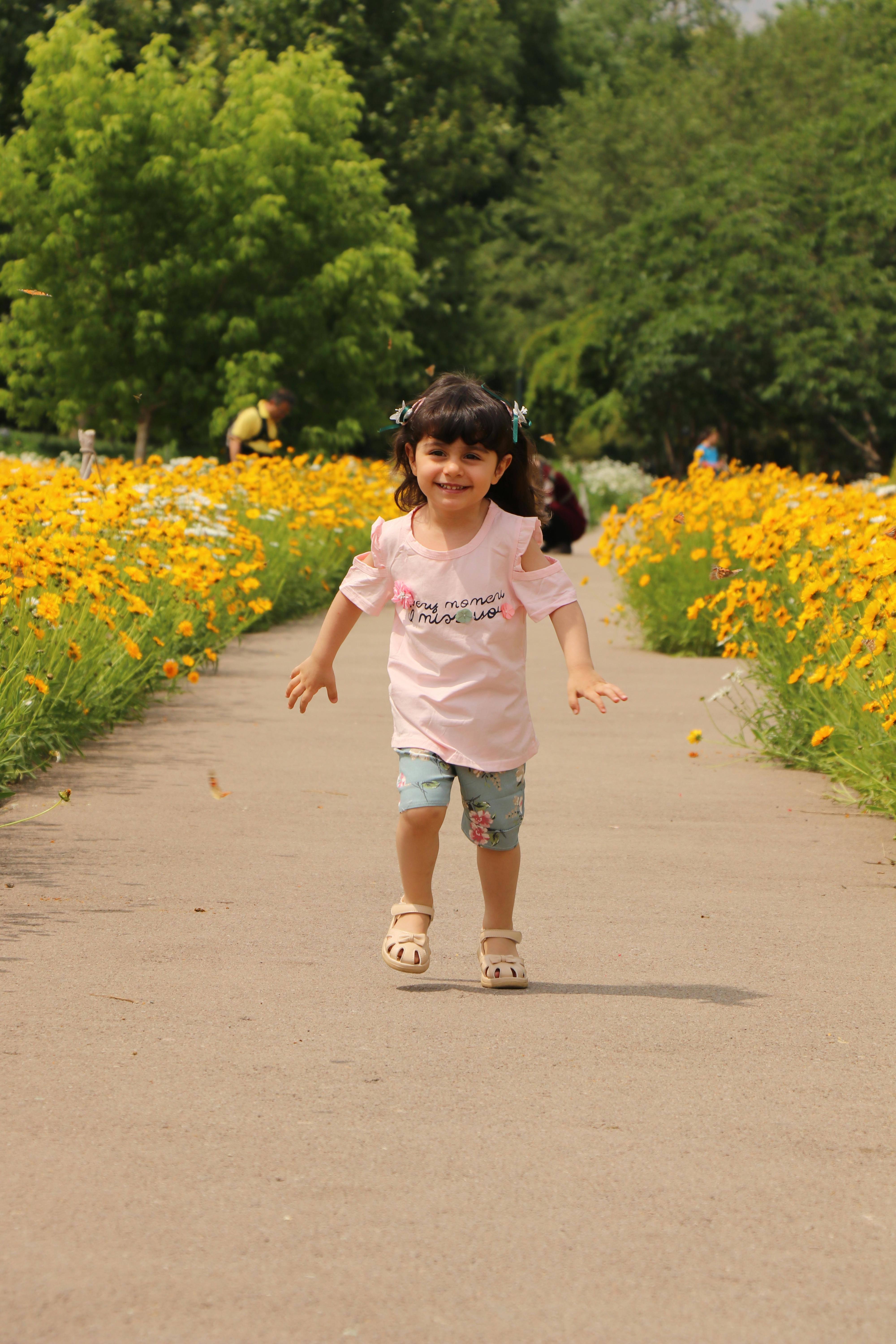Young Girl Enjoying a Walk in Blooming Park · Free Stock Photo