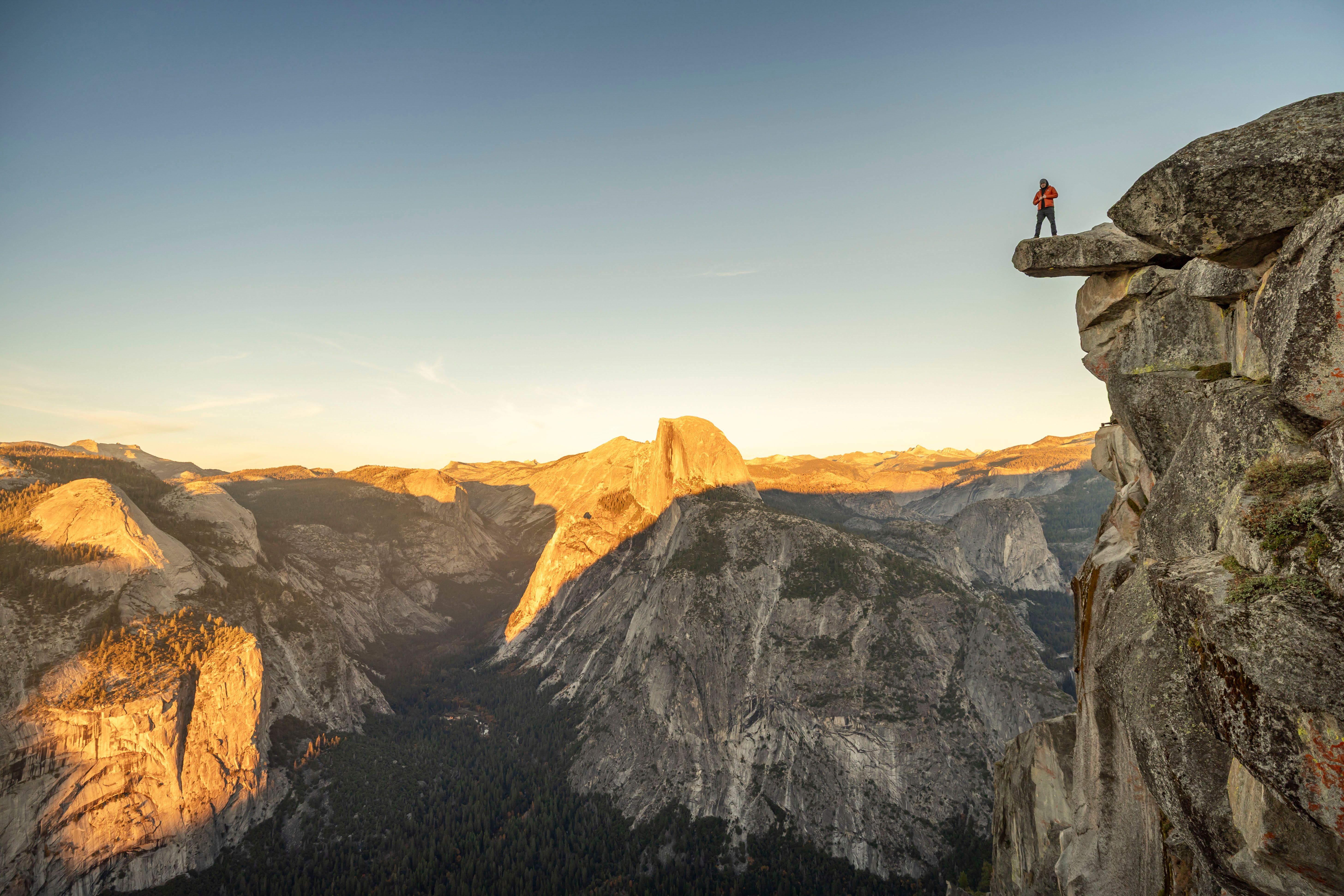 Hiker on Cliff Overlooking Yosemite's Half Dome · Free Stock Photo