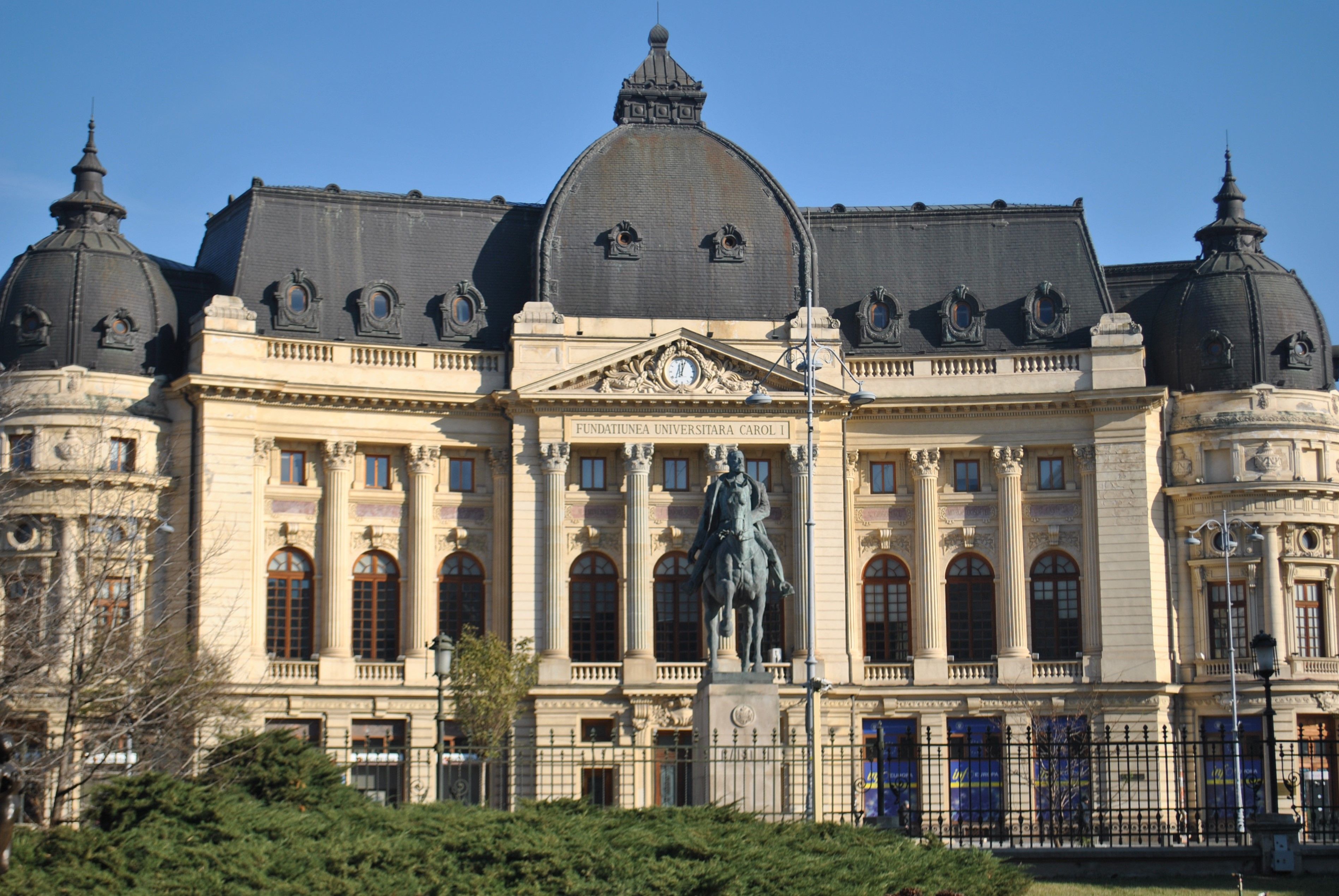 Historic University Building with Equestrian Statue · Free Stock Photo