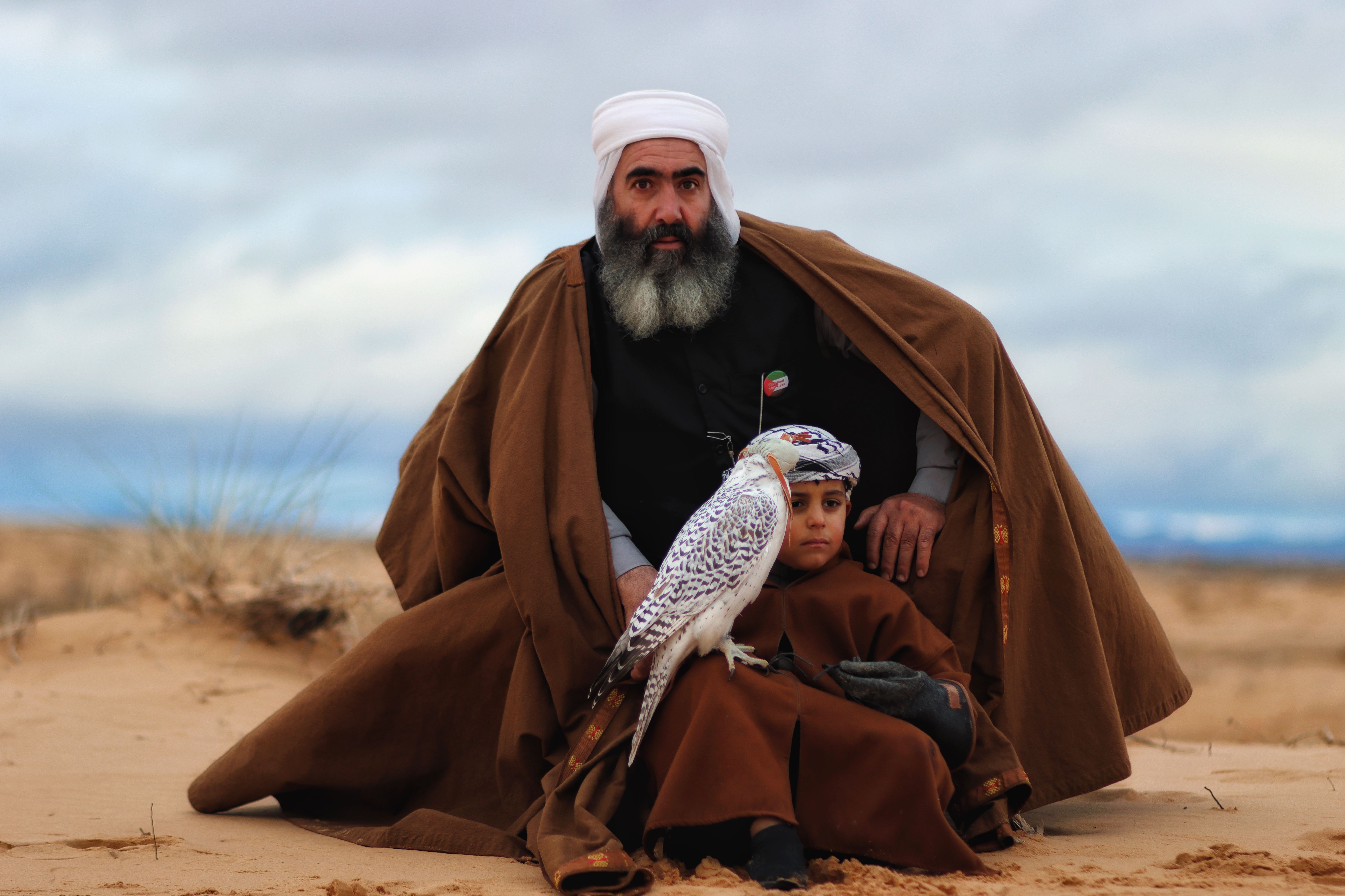 Ayah Dan Anak Bersama Burung Elang Di Gurun Aljazair · Foto Stok Gratis