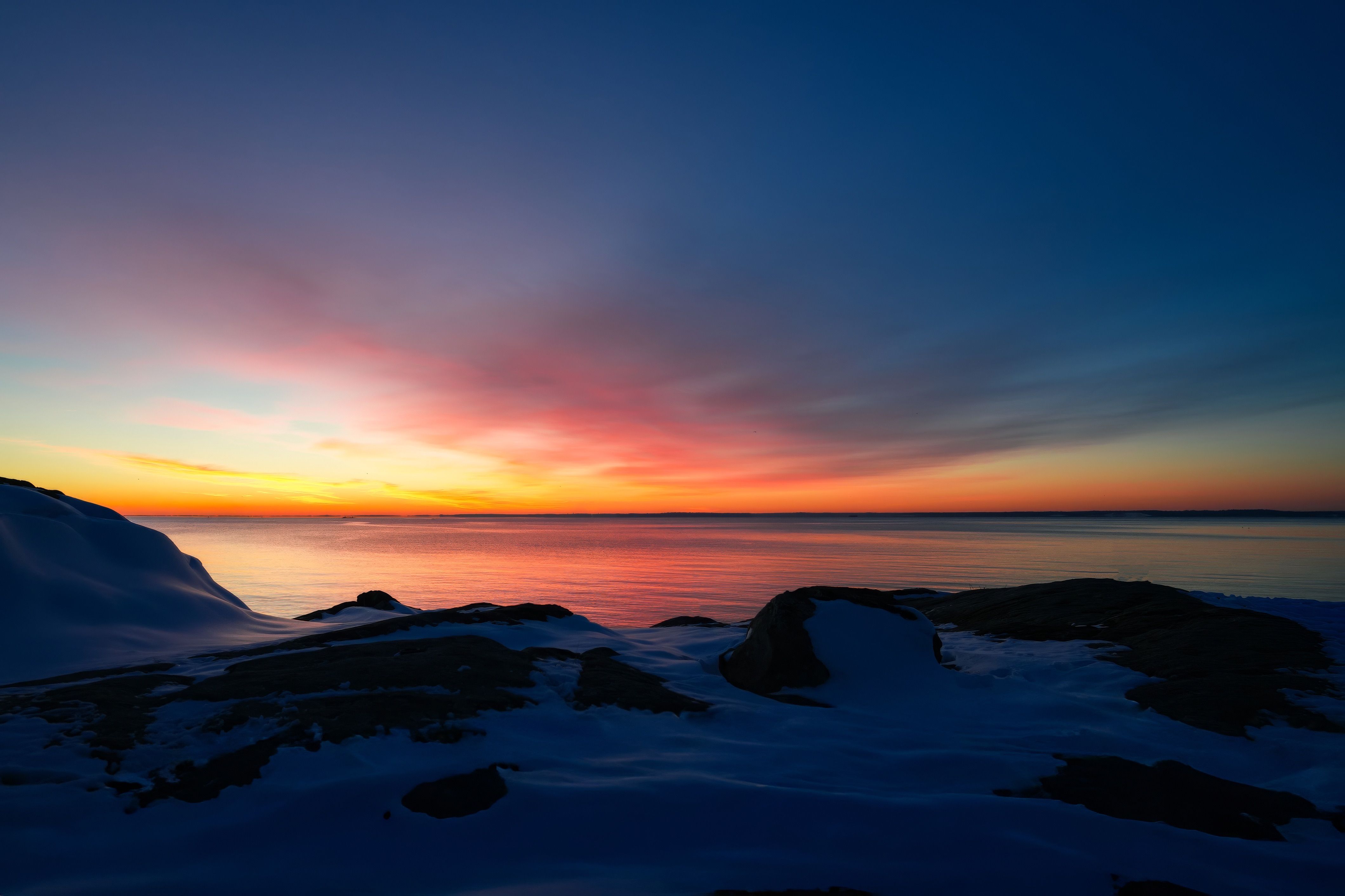 Serene Winter Sunset Over Icy Shoreline · Free Stock Photo