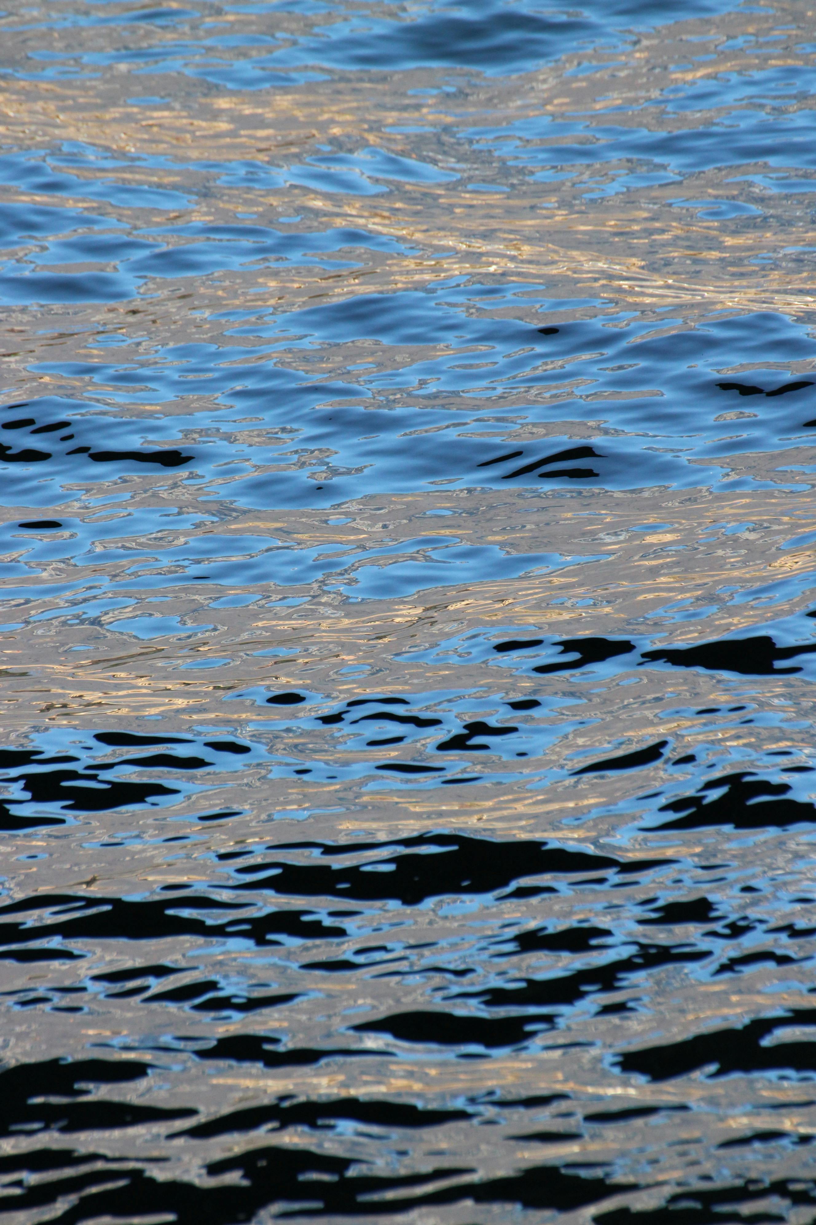 Serene Blue Water Surface at Sunset · Free Stock Photo