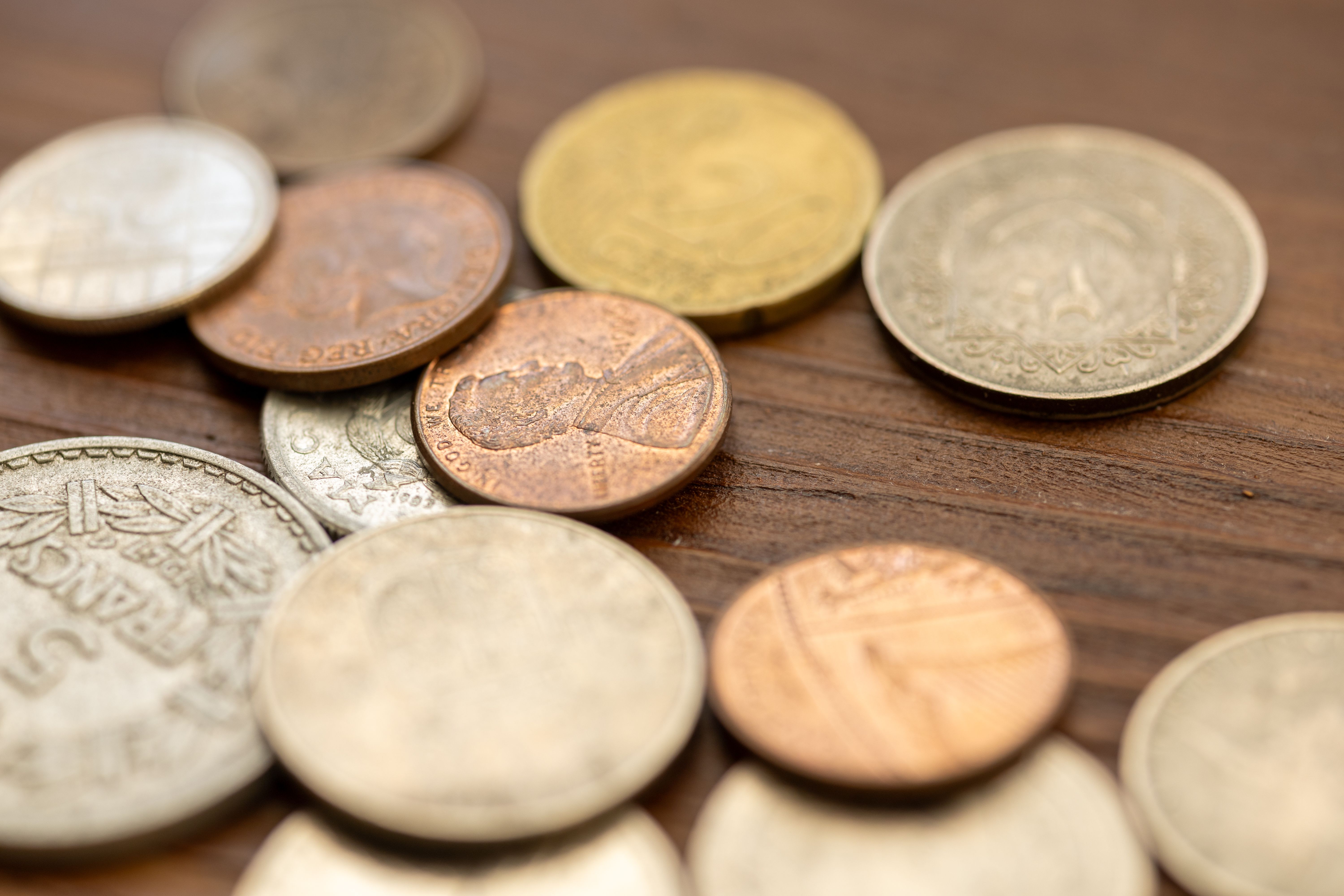 Close-up of Assorted Vintage Coins on Wooden Surface · Free Stock Photo