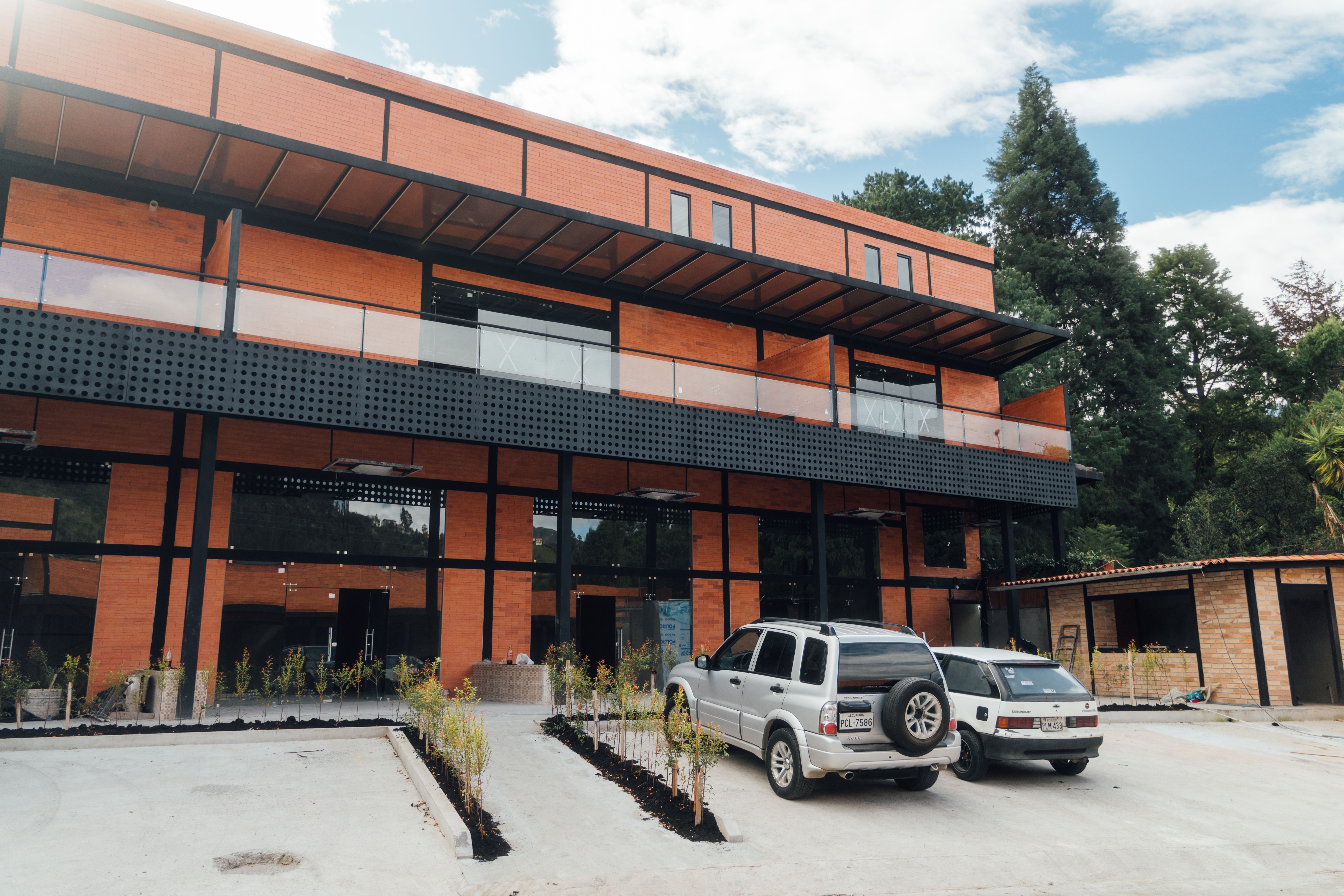Modern Brick Building with Parked Cars Outdoors · Free Stock Photo