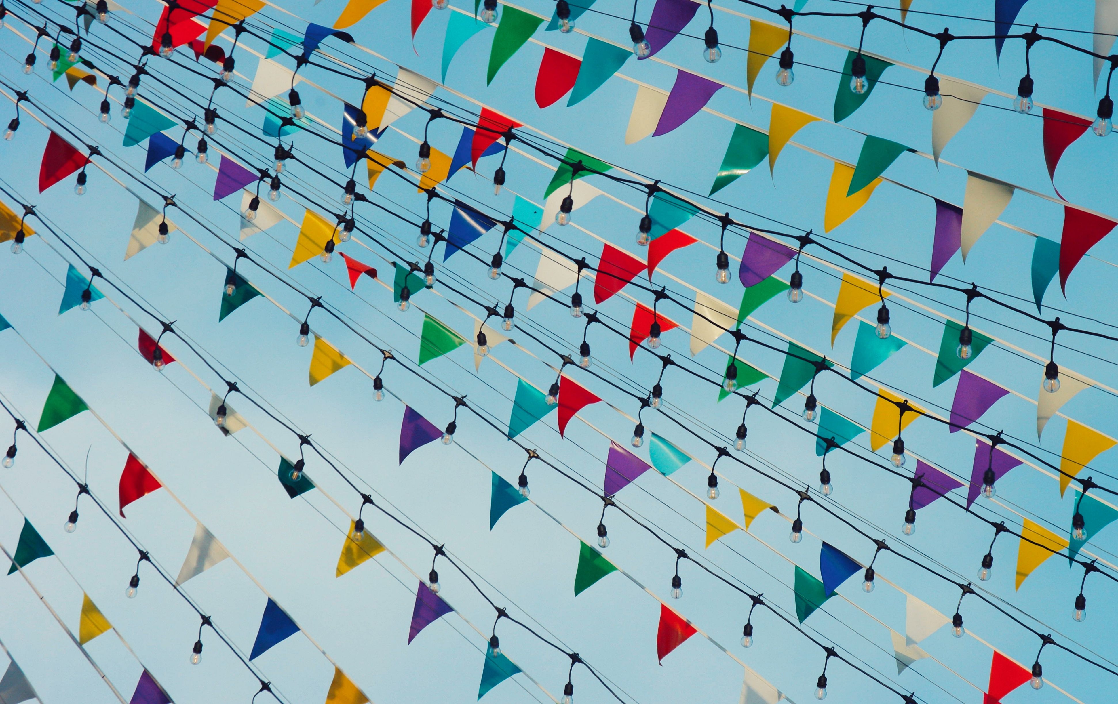 Colorful Festival Flags Under Blue Sky · Free Stock Photo
