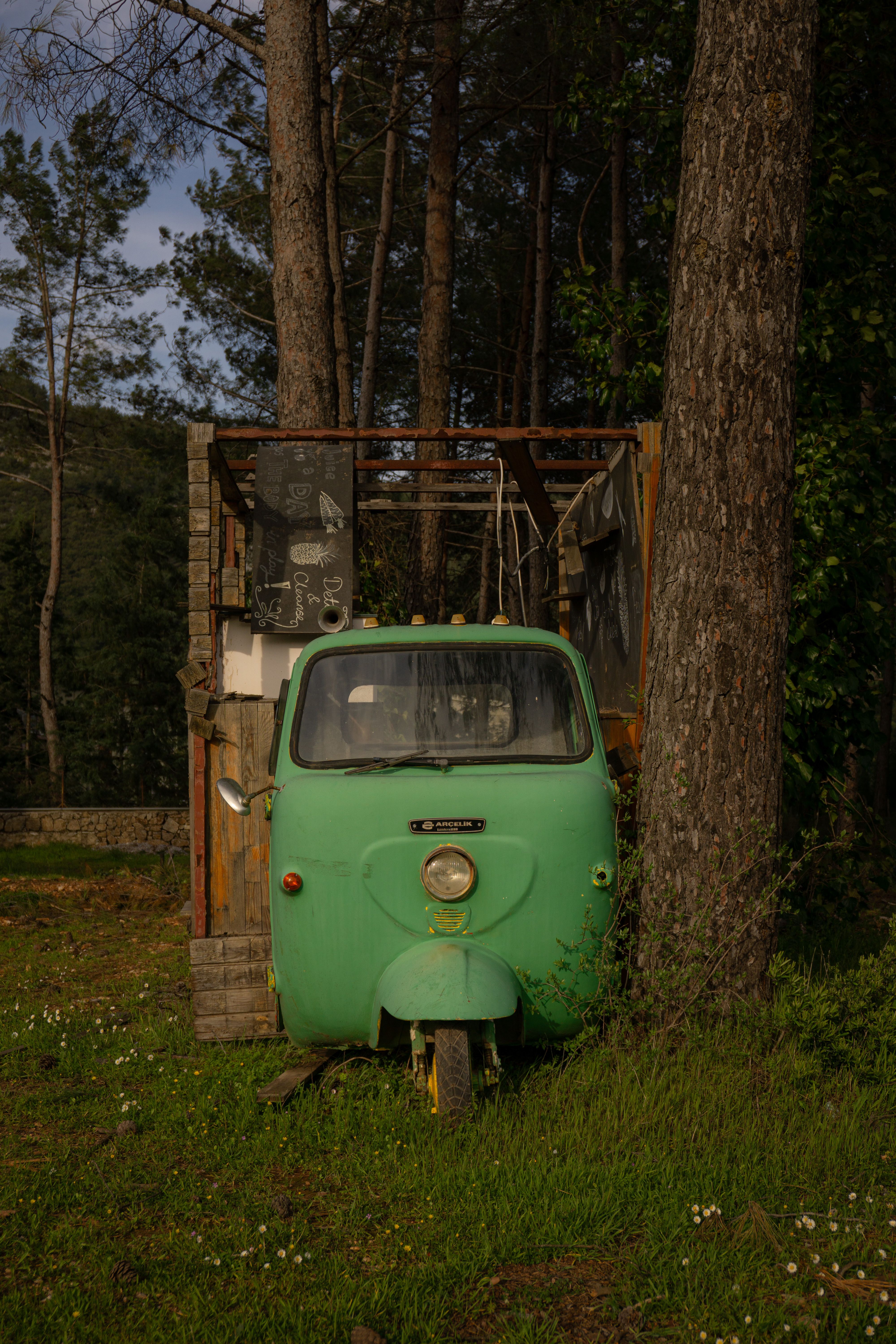 Vintage Green Three-Wheeler in Forest Setting · Free Stock Photo