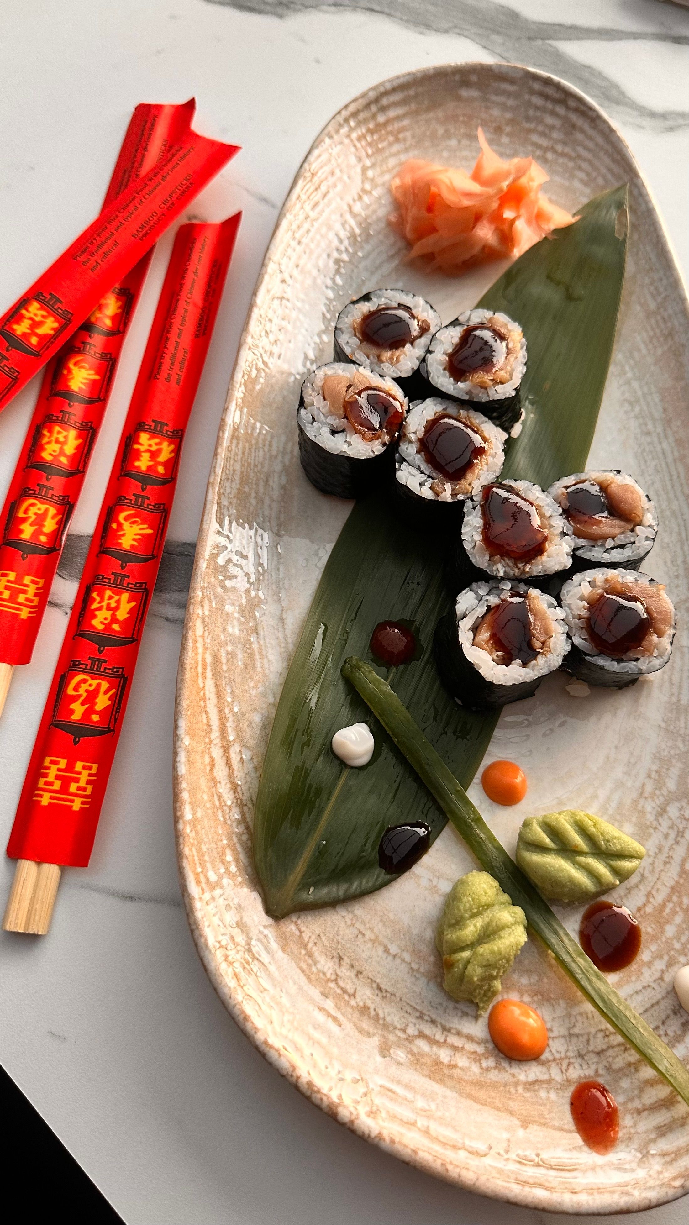 Delicious Sushi Roll on Ceramic Plate with Chopsticks · Free Stock Photo