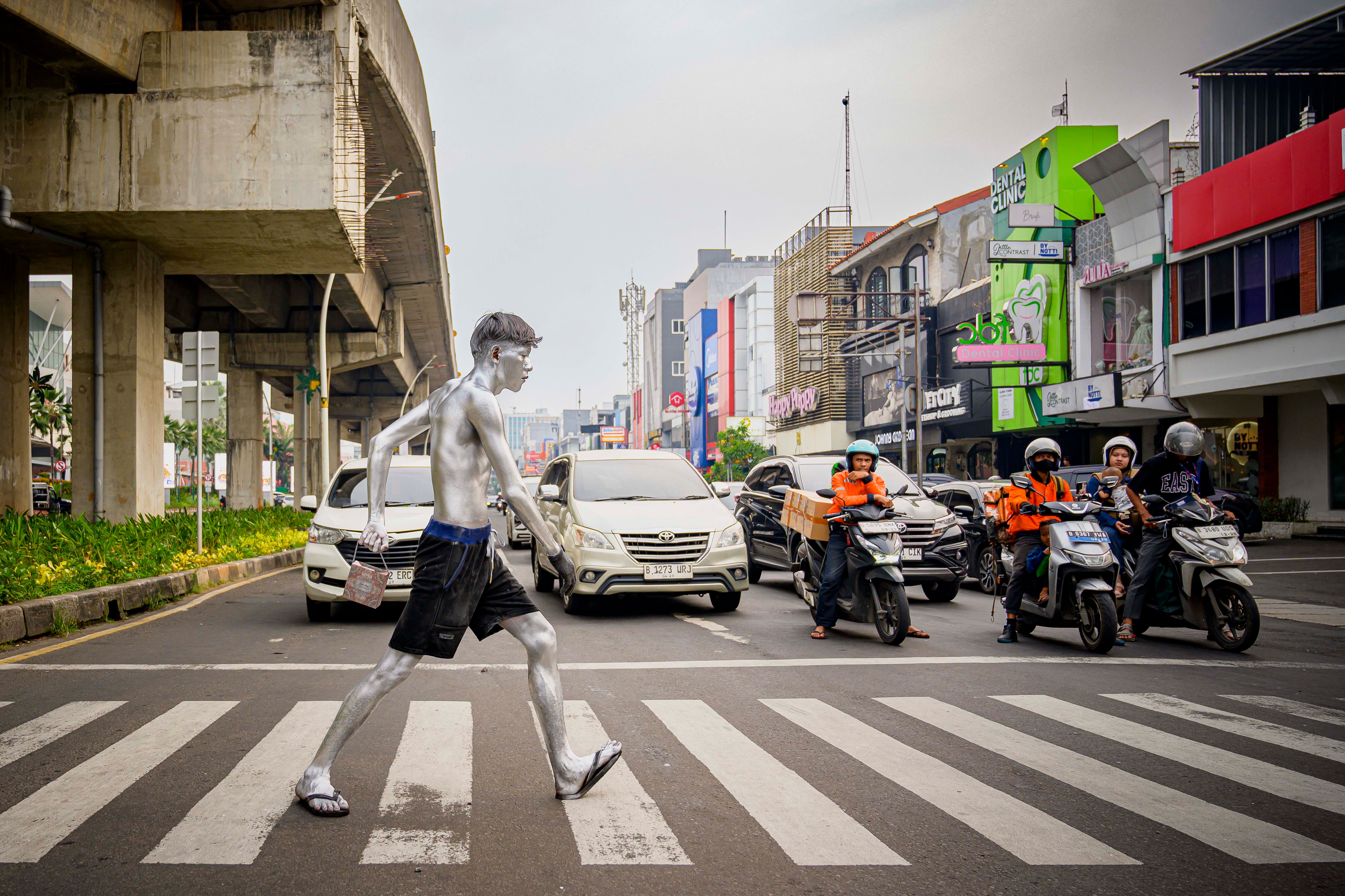 Man Painted Silver Crossing Urban Street · Free Stock Photo
