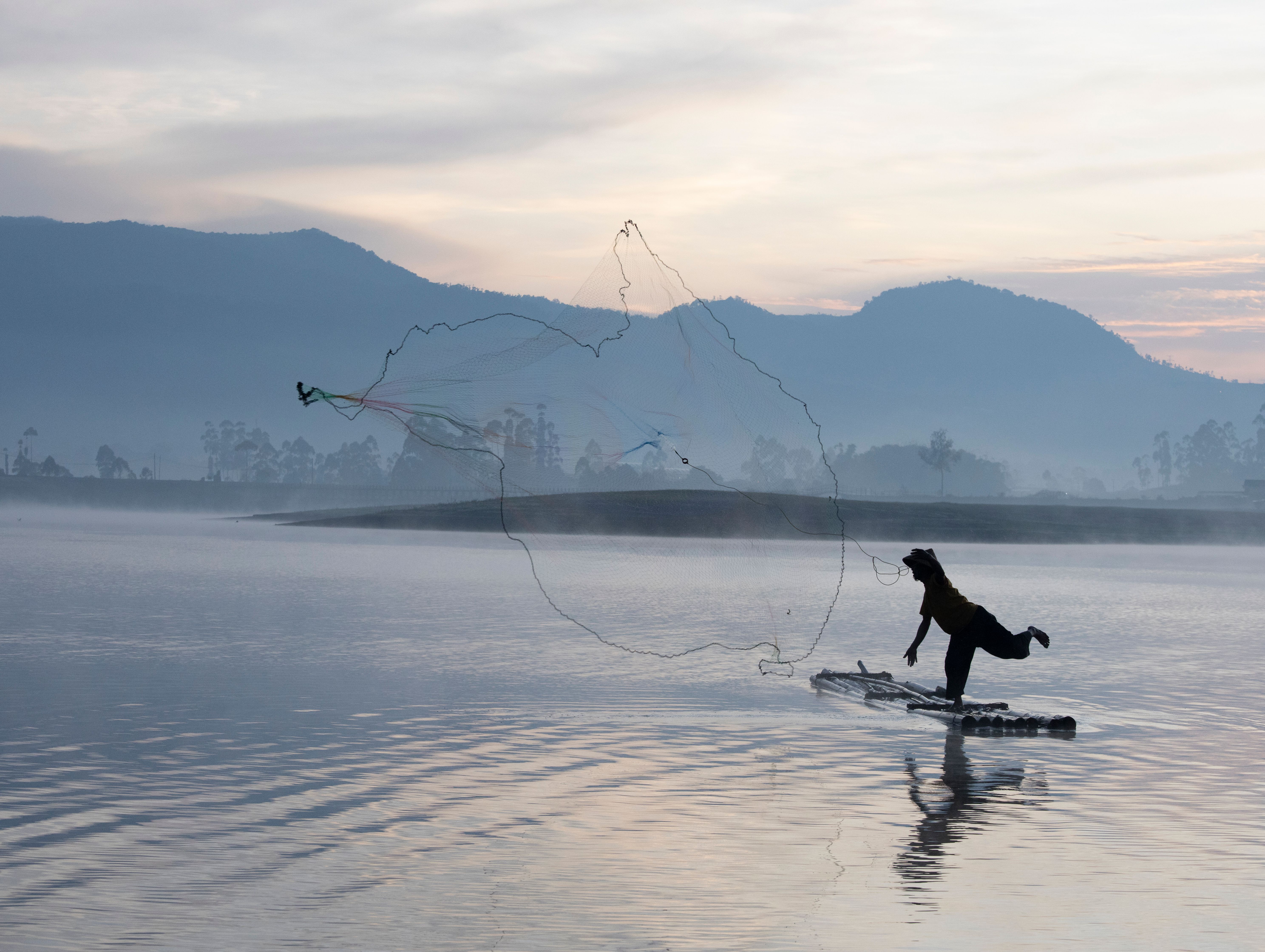 Pescador Lançando Rede Ao Nascer Do Sol Em Um Lago Em Java. · Foto ...