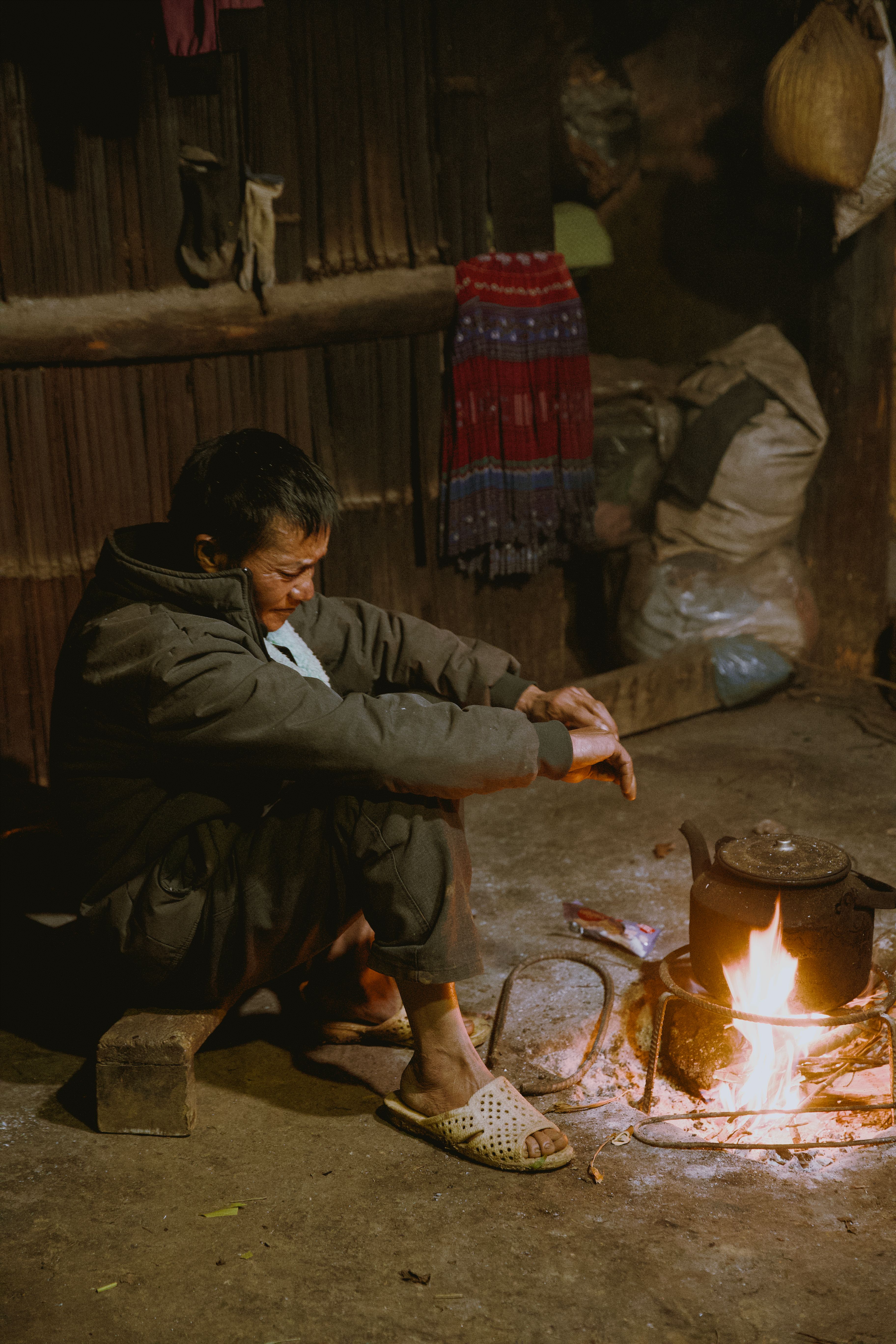 Man Warming by Fire in Rustic Setting · Free Stock Photo