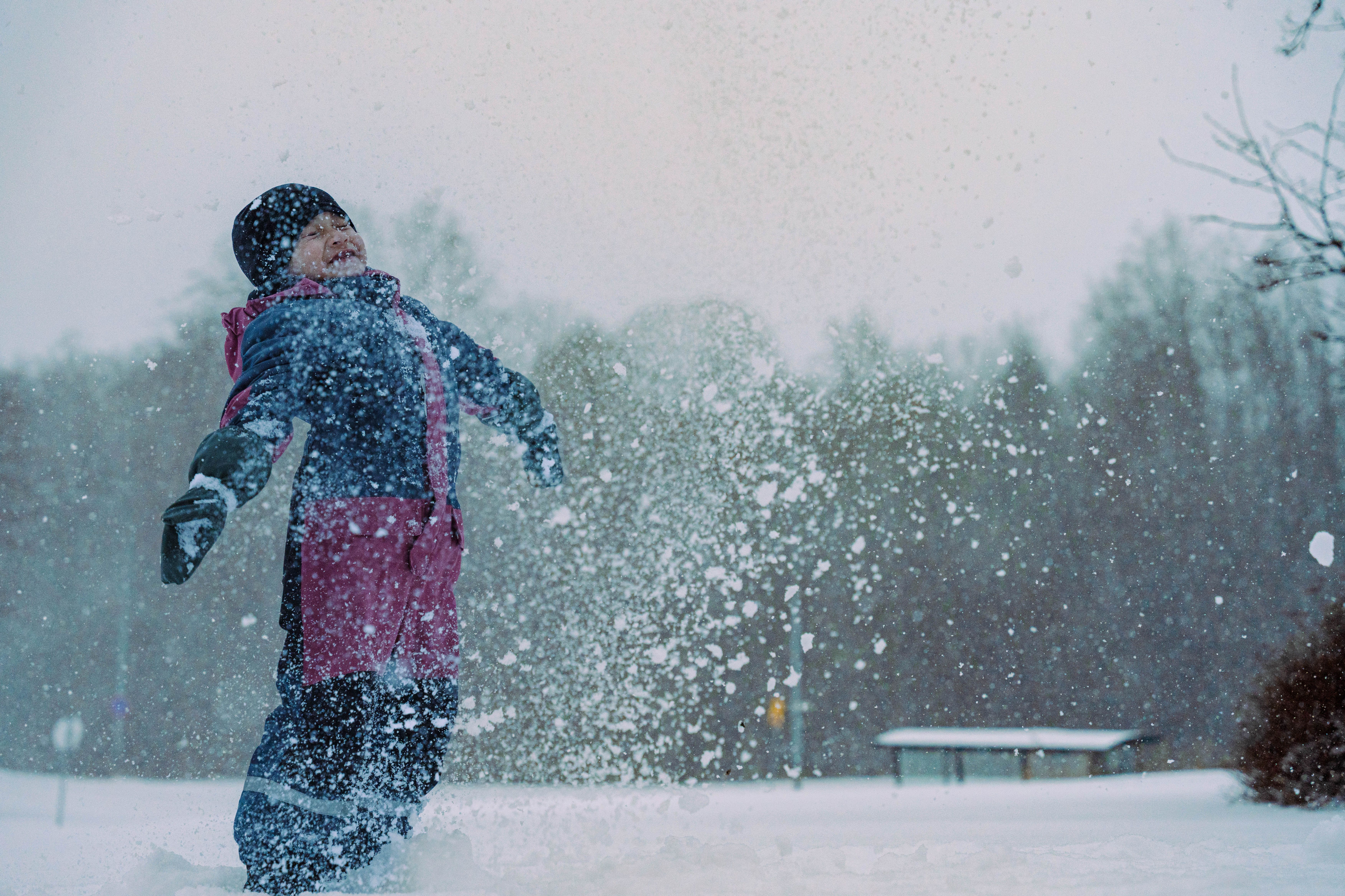Joyful Child Playing in Winter Snowfall · Free Stock Photo