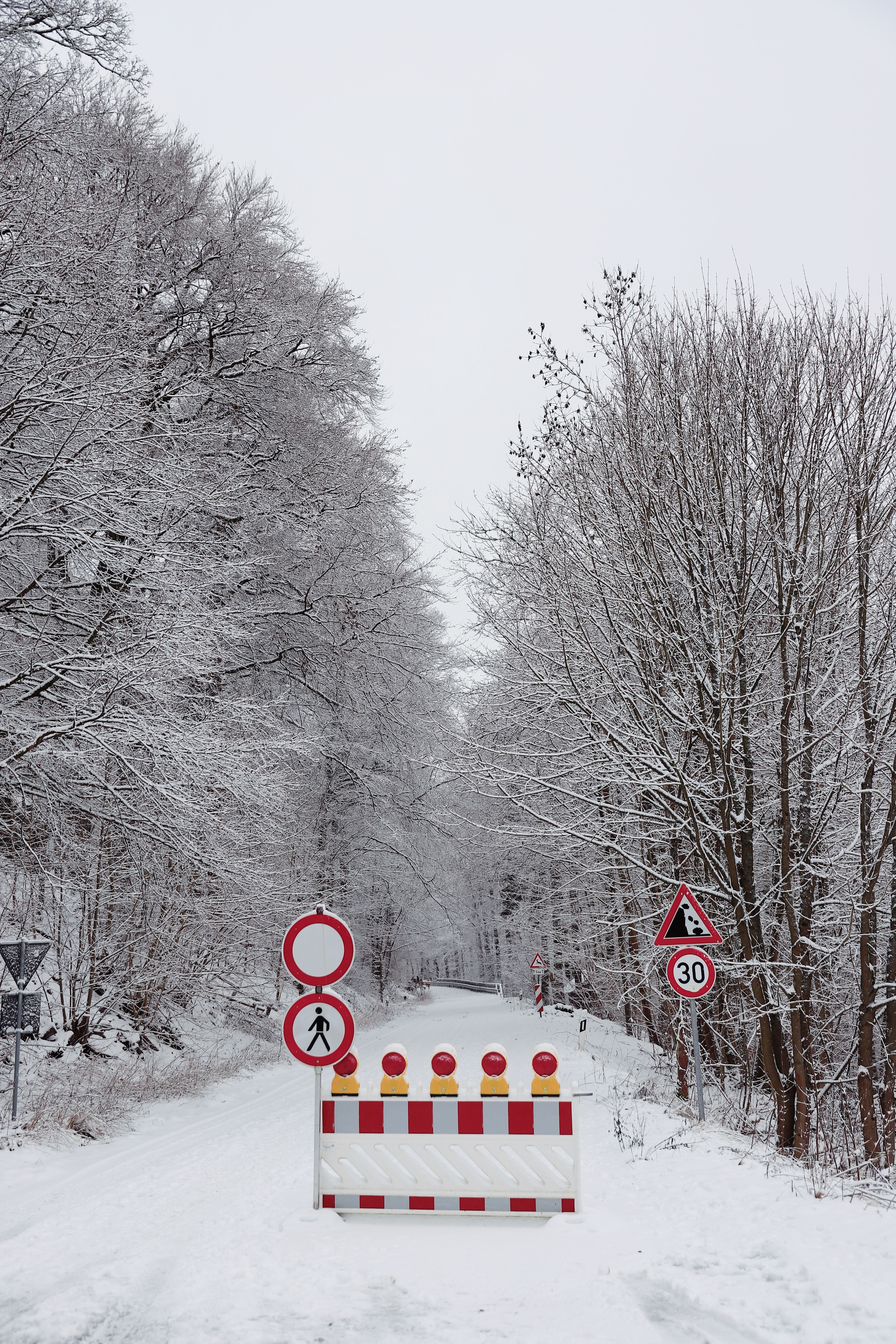 Snow-Covered Road with Warning Signs in Winter · Free Stock Photo