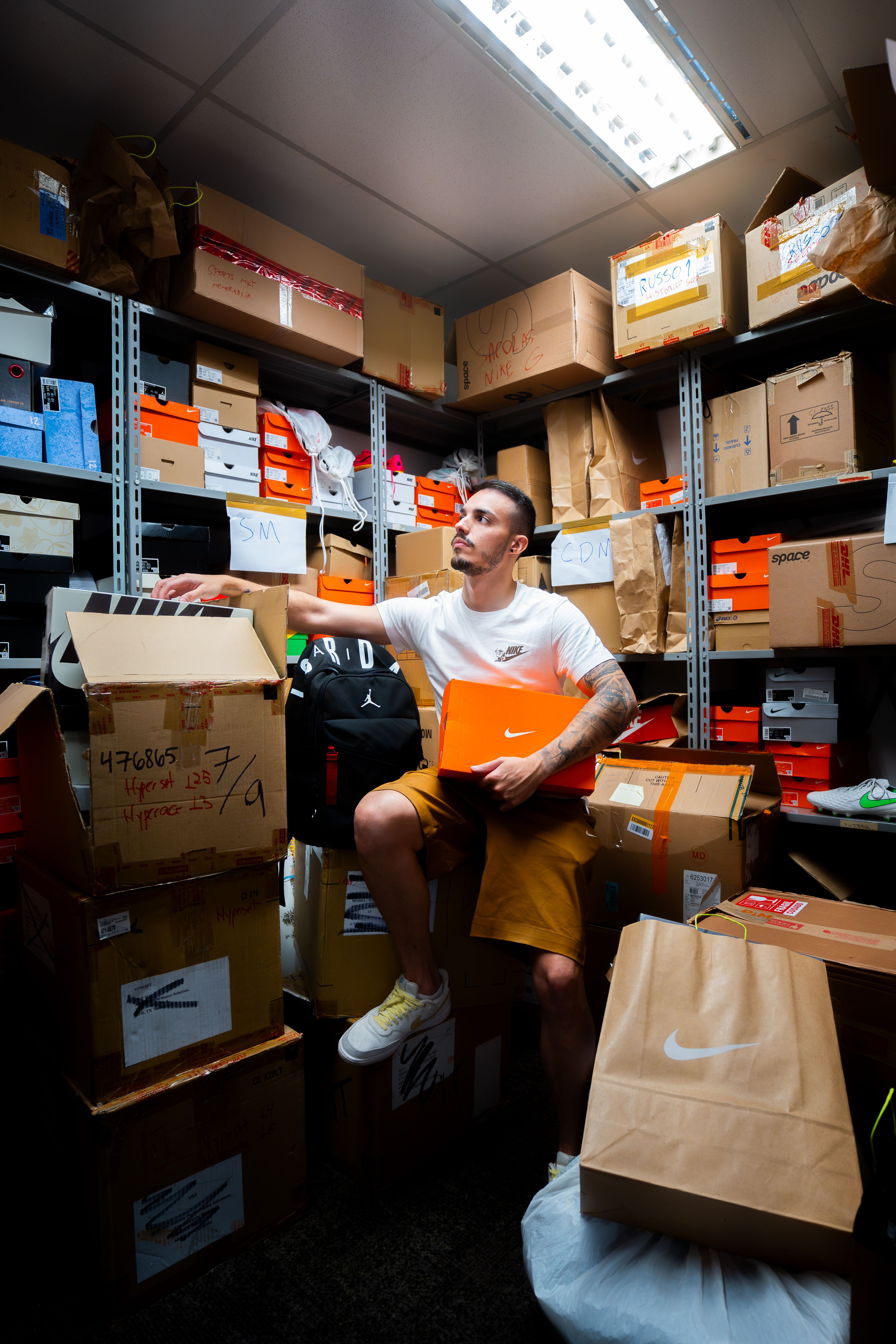 Man Sorting Shoe Boxes in Inventory Room · Free Stock Photo