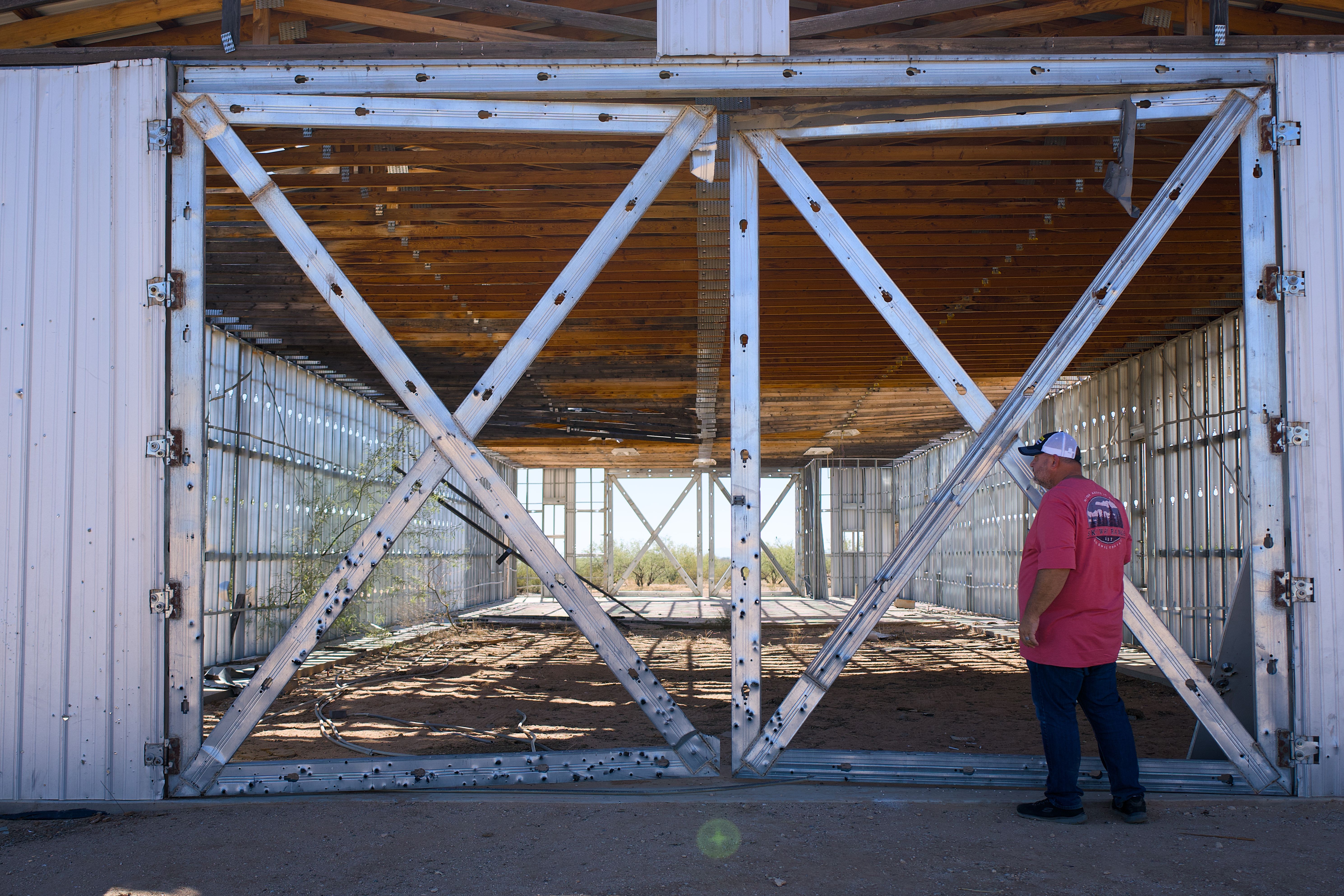 Man Inspects Large Metal Structure on Sunny Day · Free Stock Photo