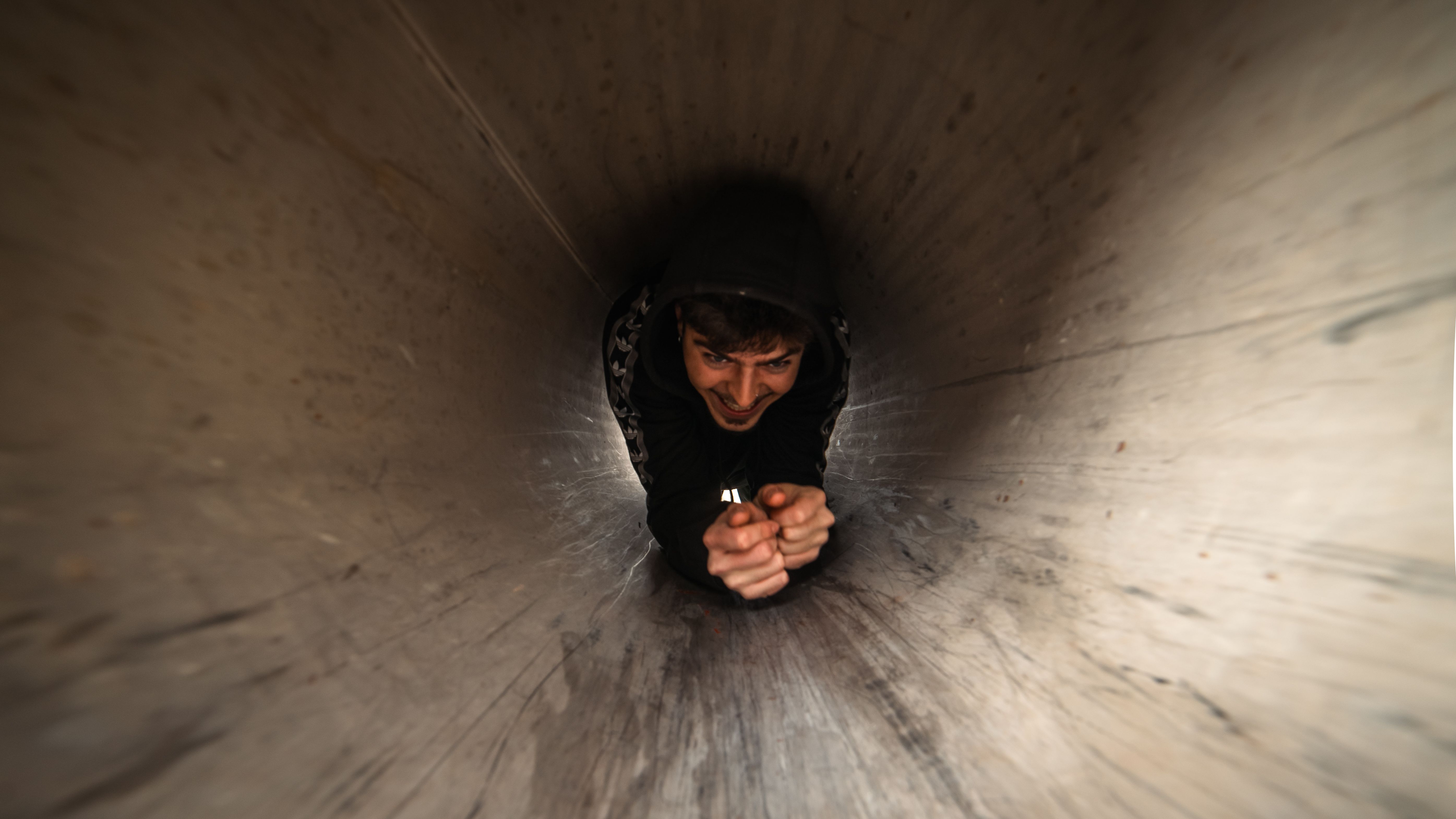 Man Crawling Inside a Metal Tunnel · Free Stock Photo