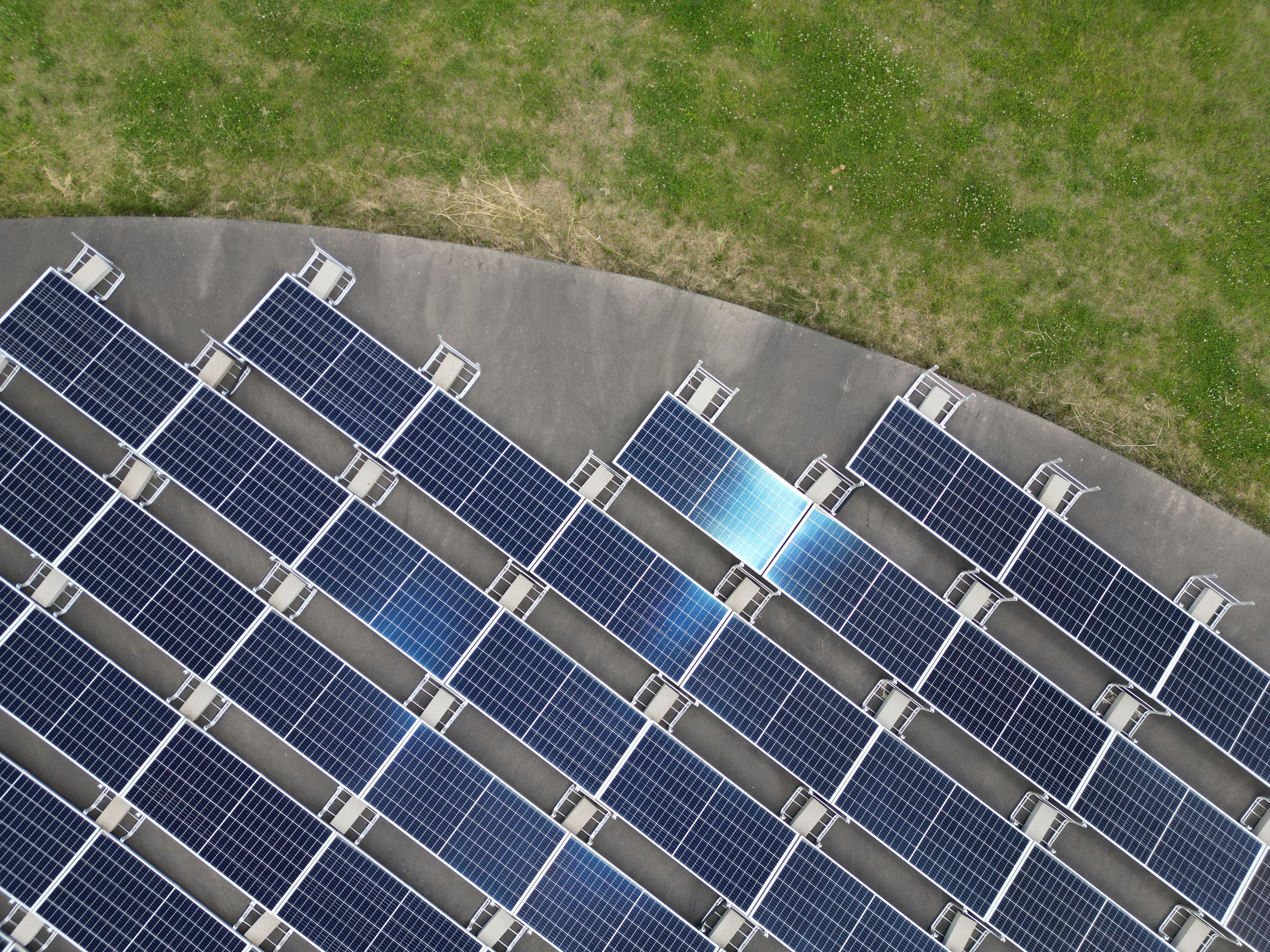 Aerial View of Solar Panels on Greenfield · Free Stock Photo