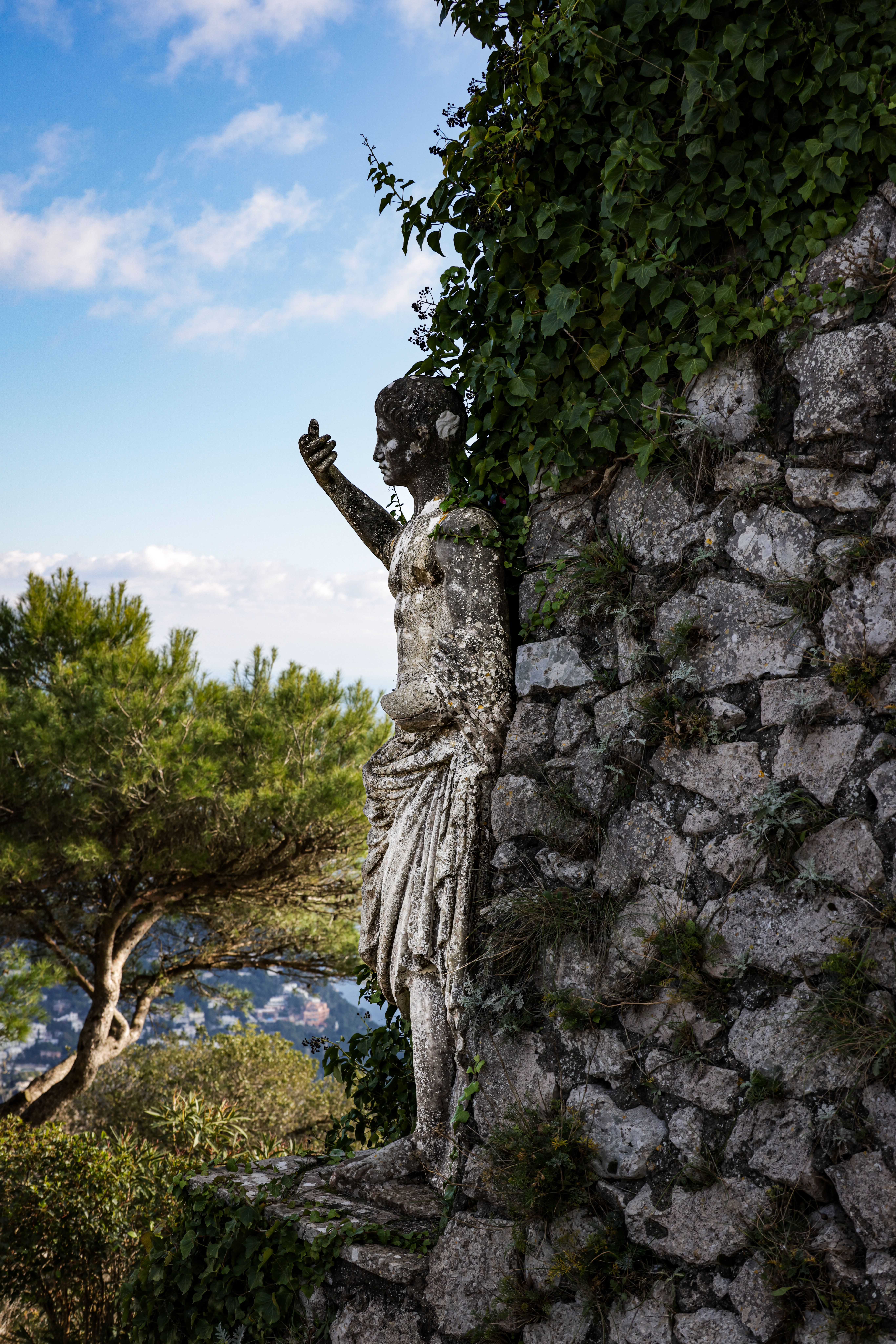 Ancient Statue in Ruins over Vine-Covered Wall · Free Stock Photo