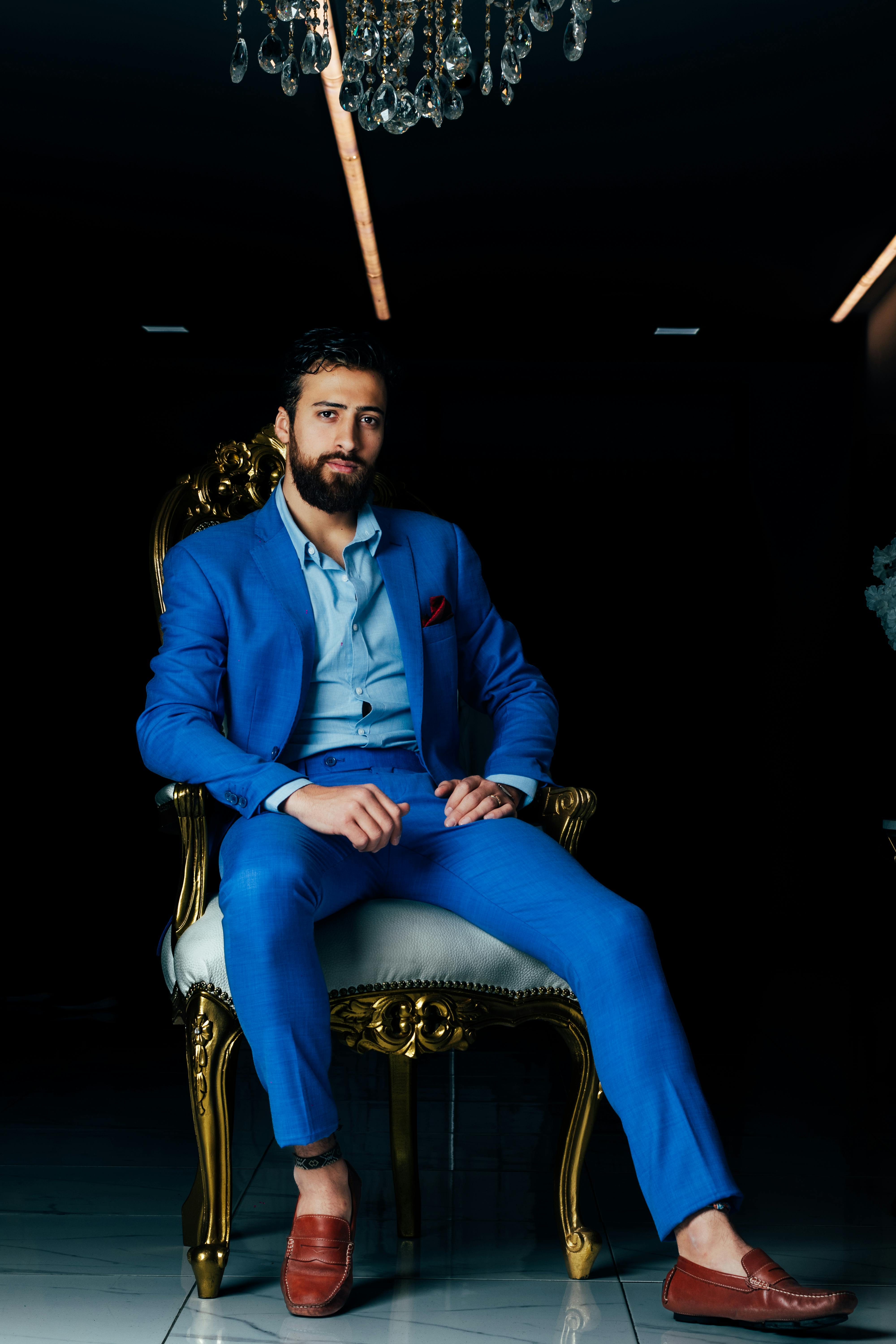 Hombre Elegante Con Traje Azul Sentado En Un Entorno De Lujo · Foto de ...