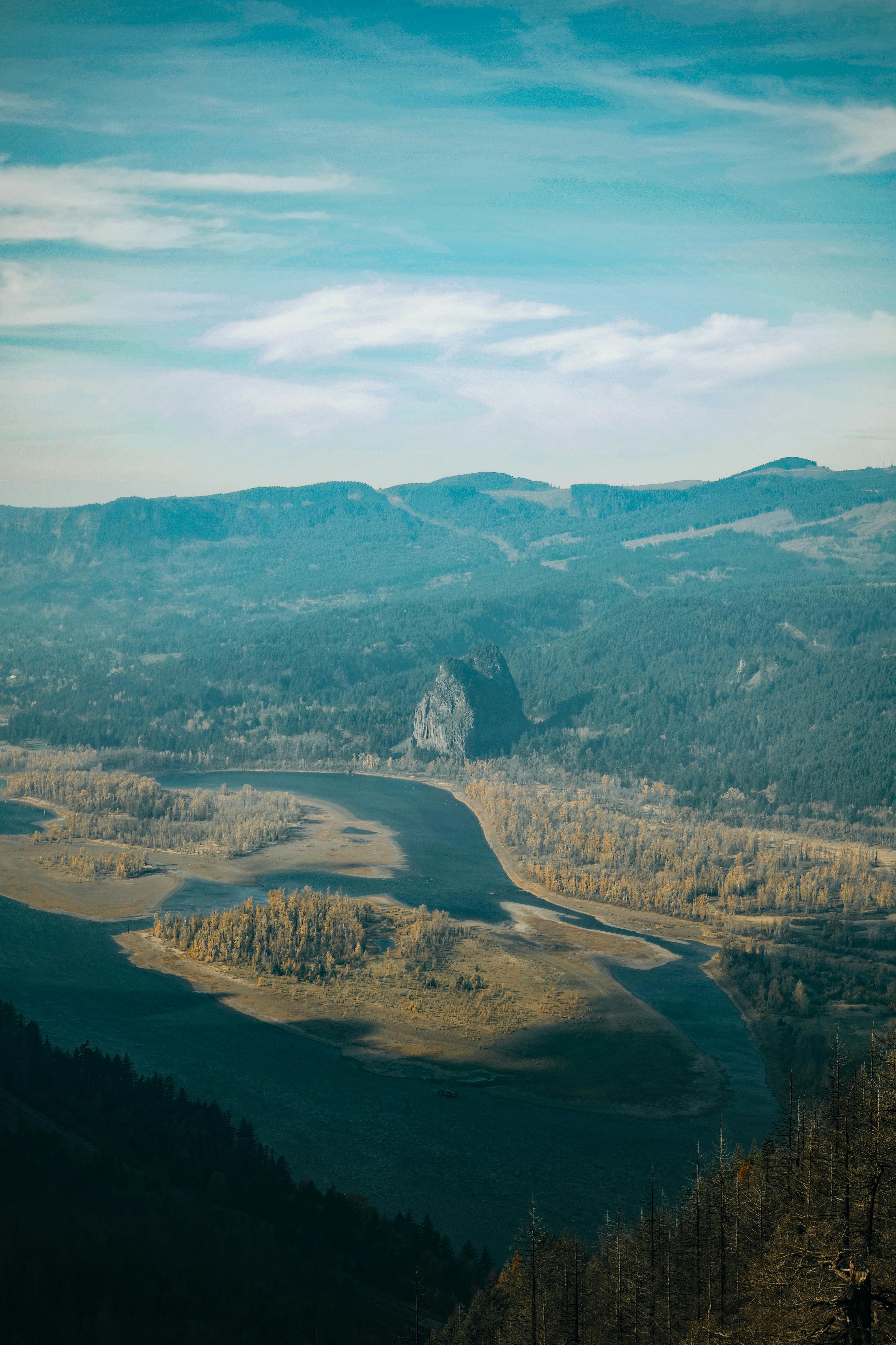 Mountain ridge and flowing river in haze · Free Stock Photo