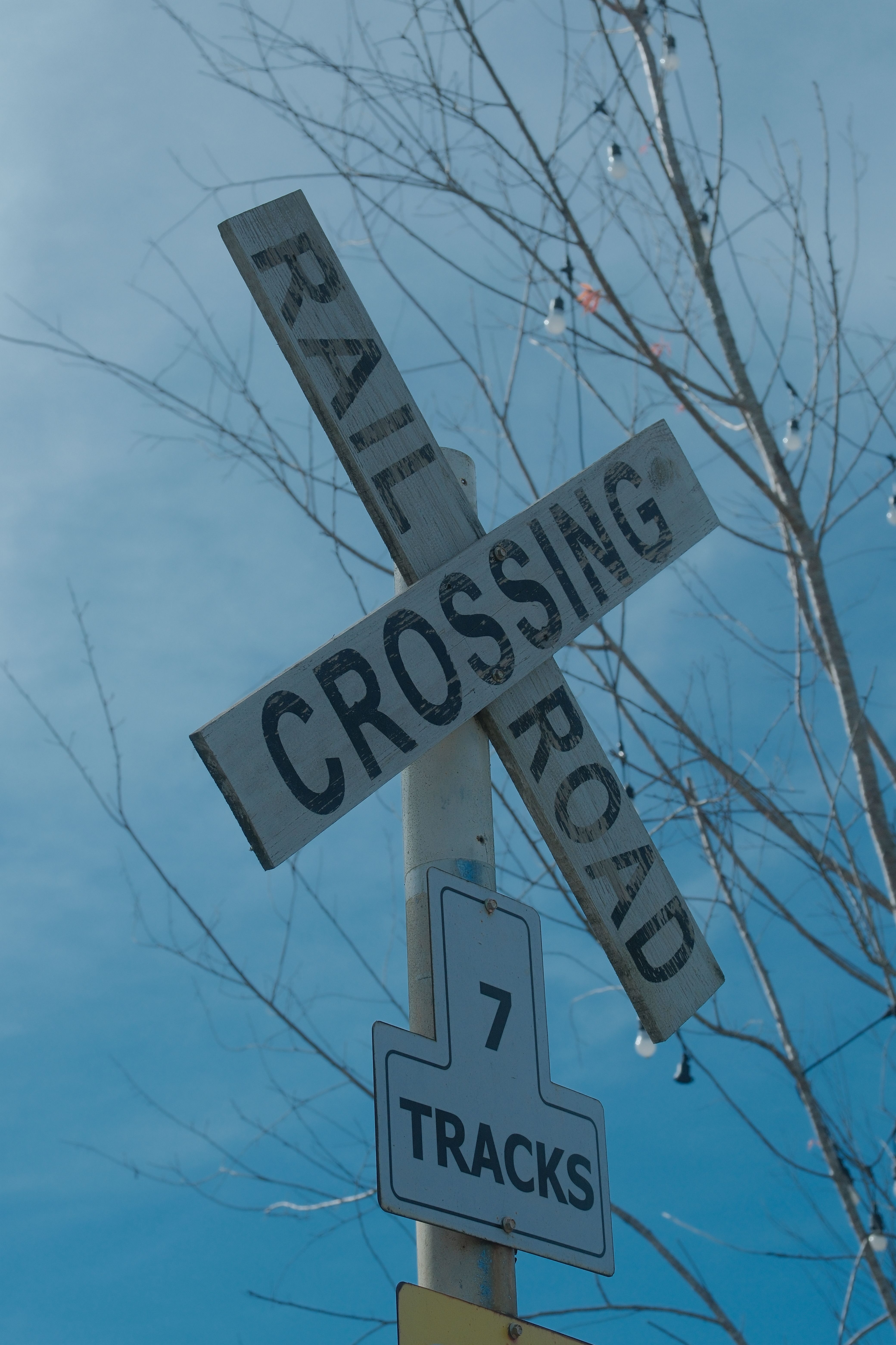 Railroad Crossing Sign Against Blue Sky · Free Stock Photo
