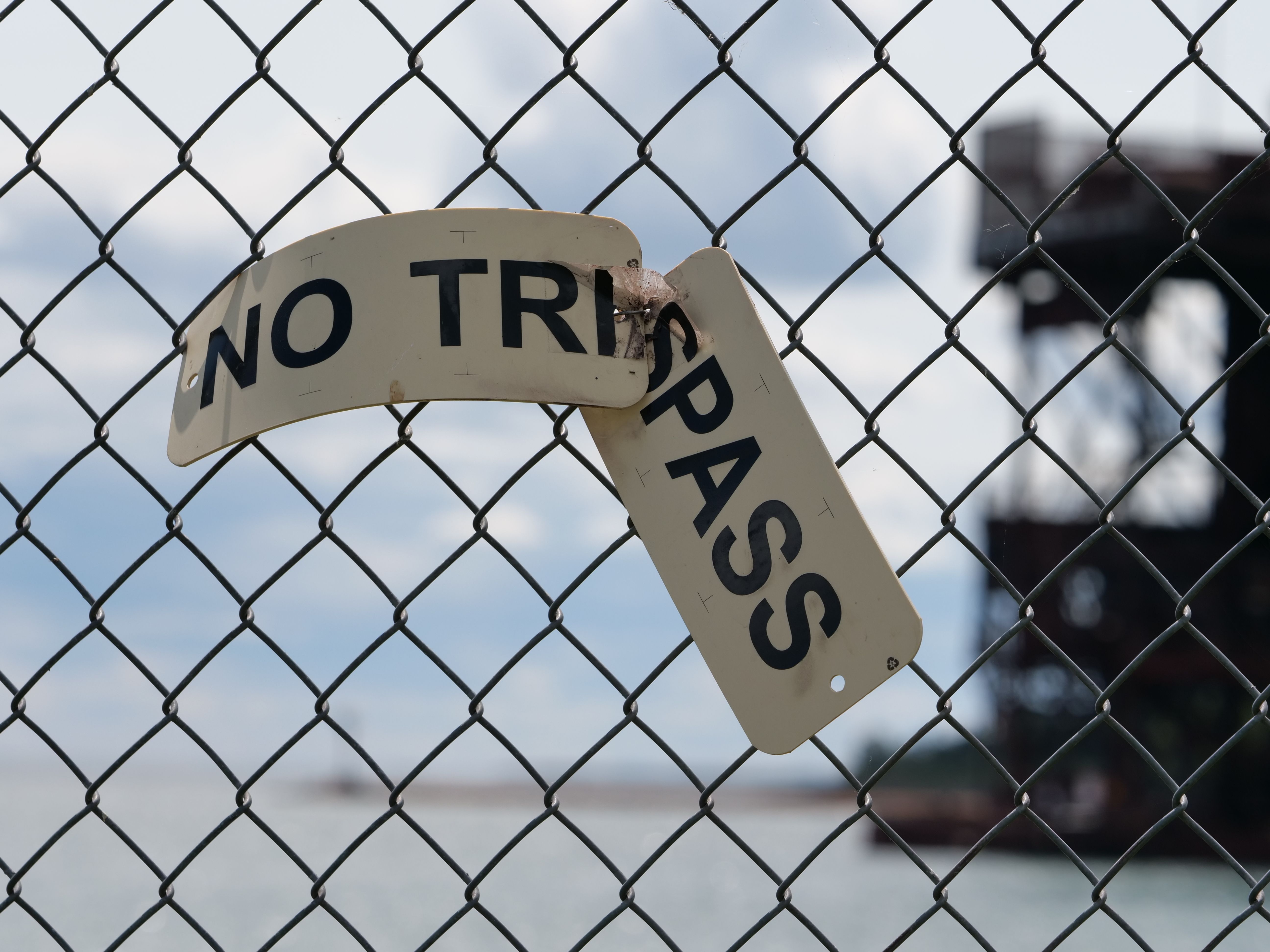 Damaged 'No Trespassing' Sign on Chain-Link Fence · Free Stock Photo