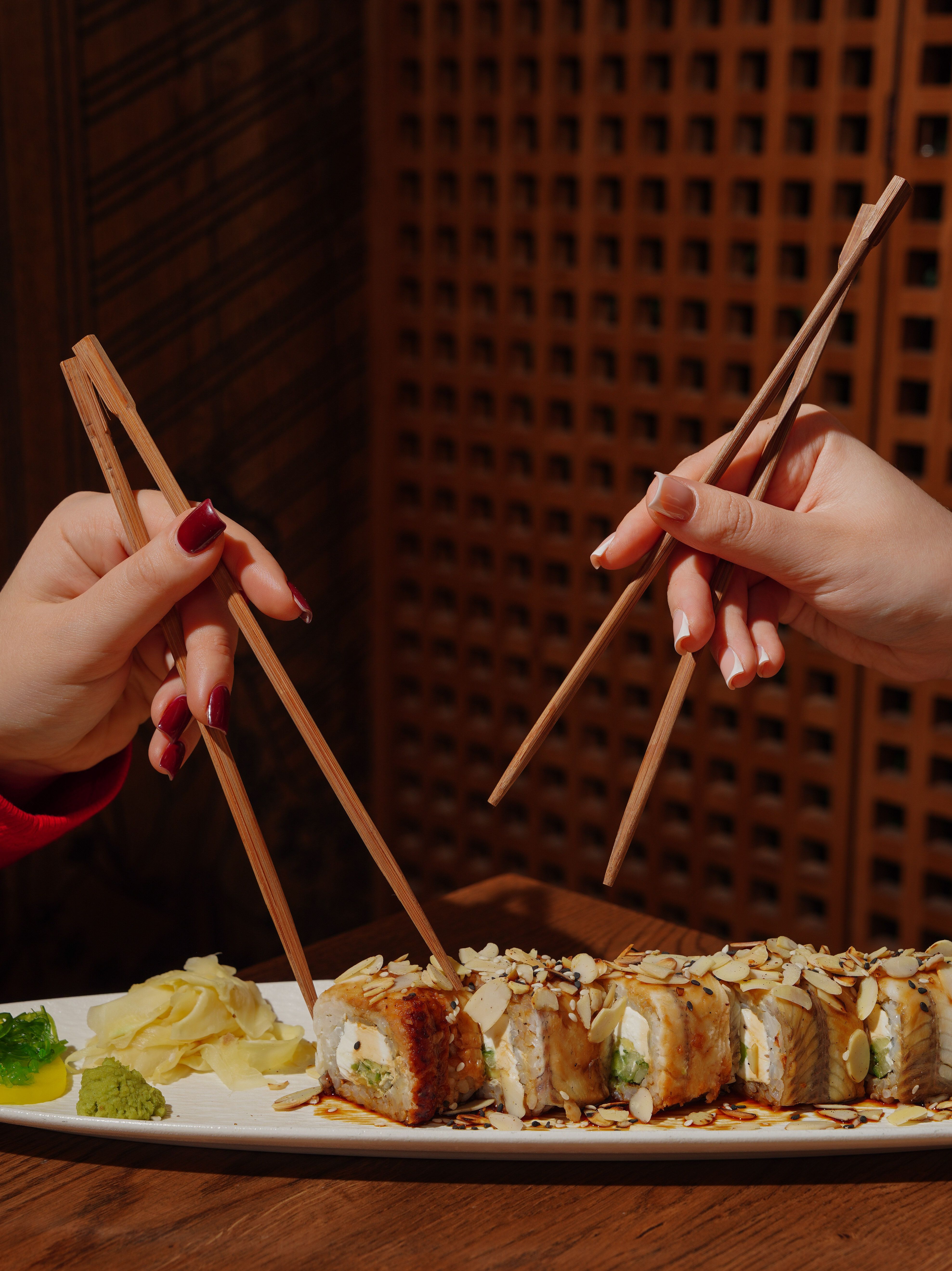 Diverse Hands Sharing Sushi Dish with Chopsticks · Free Stock Photo