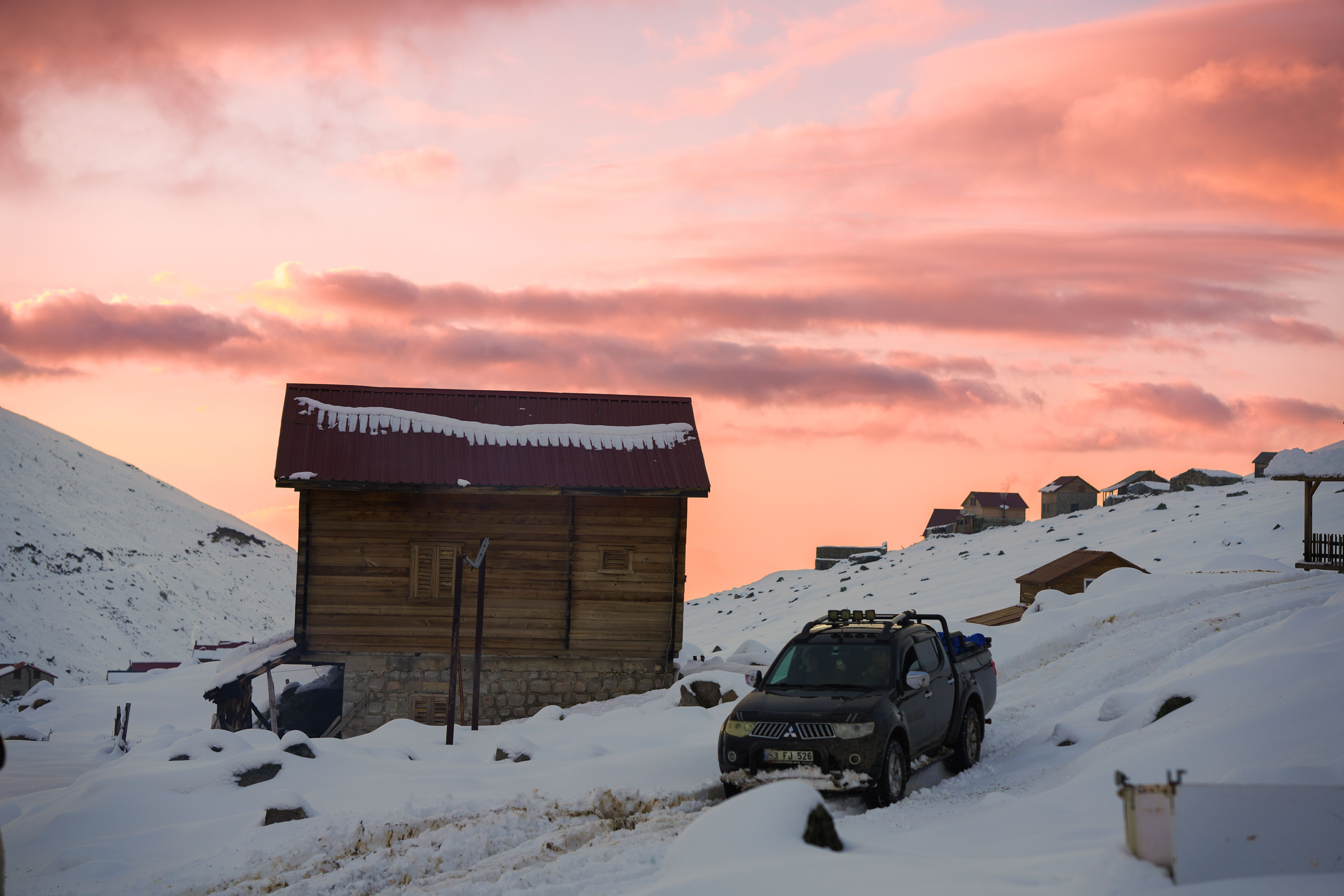 Snowy Mountain Cabin with Off-Road Vehicle at Sunset · Free Stock Photo