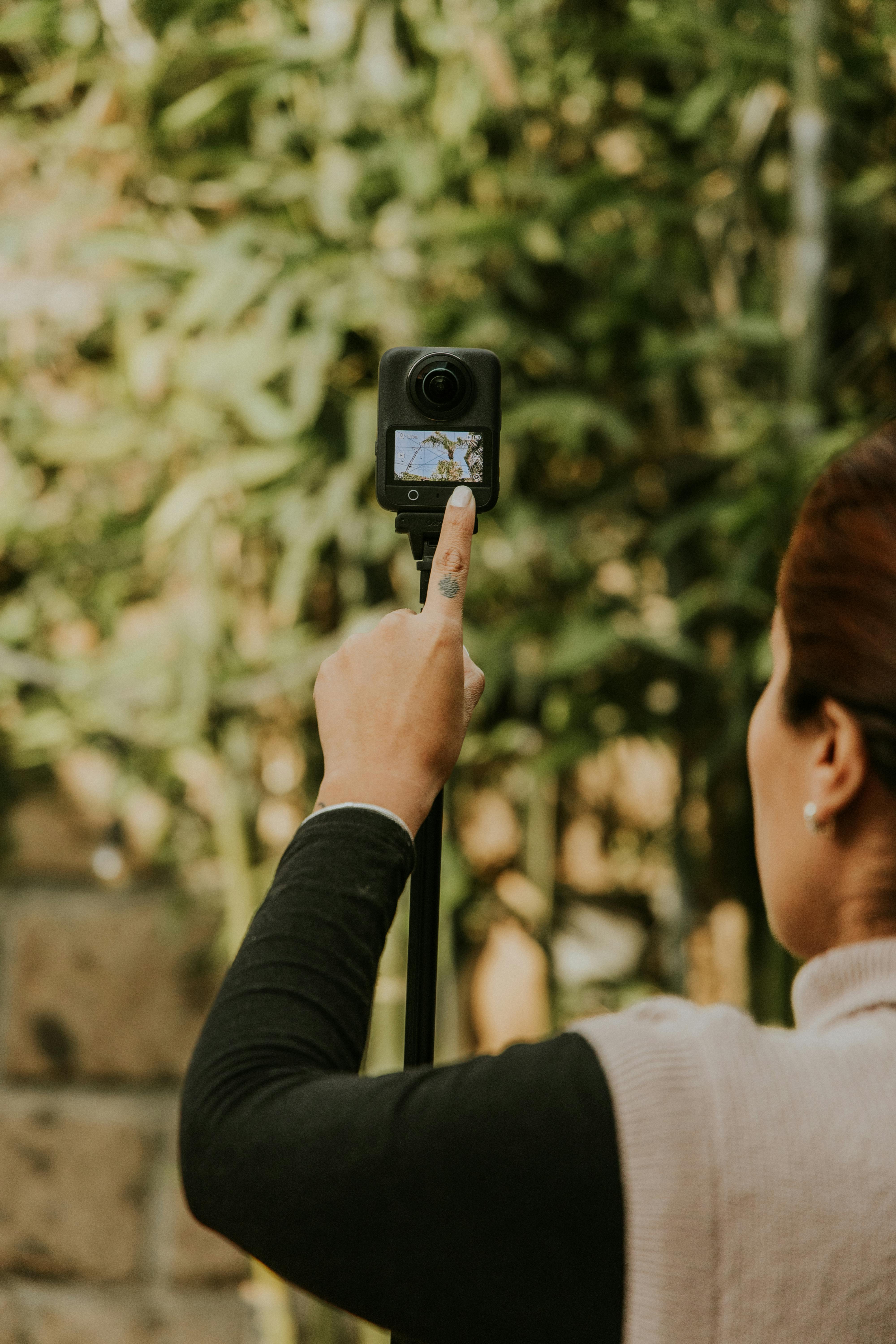 Person Using 360 Camera for Outdoor Photography · Free Stock Photo
