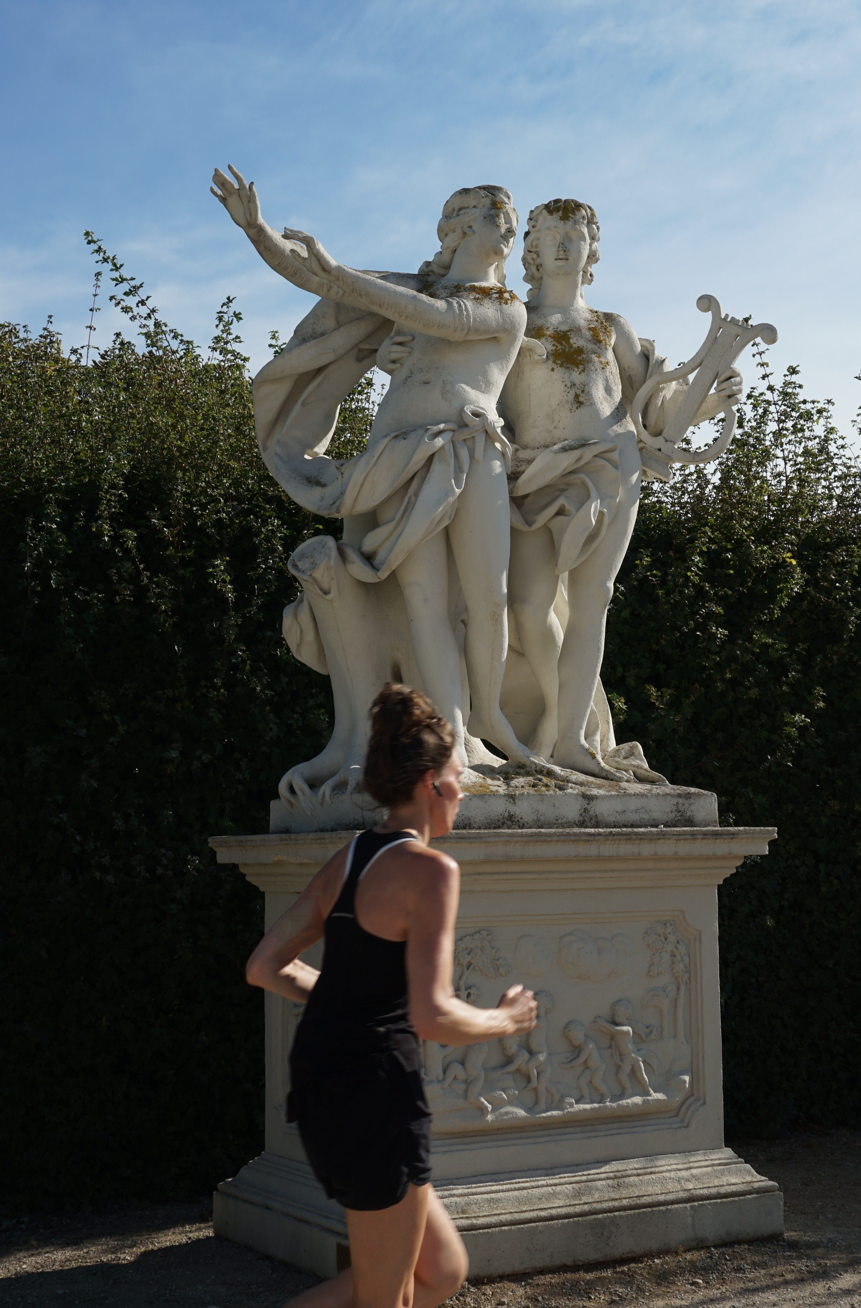Jogger Passing Classical Marble Sculpture Outdoors · Free Stock Photo