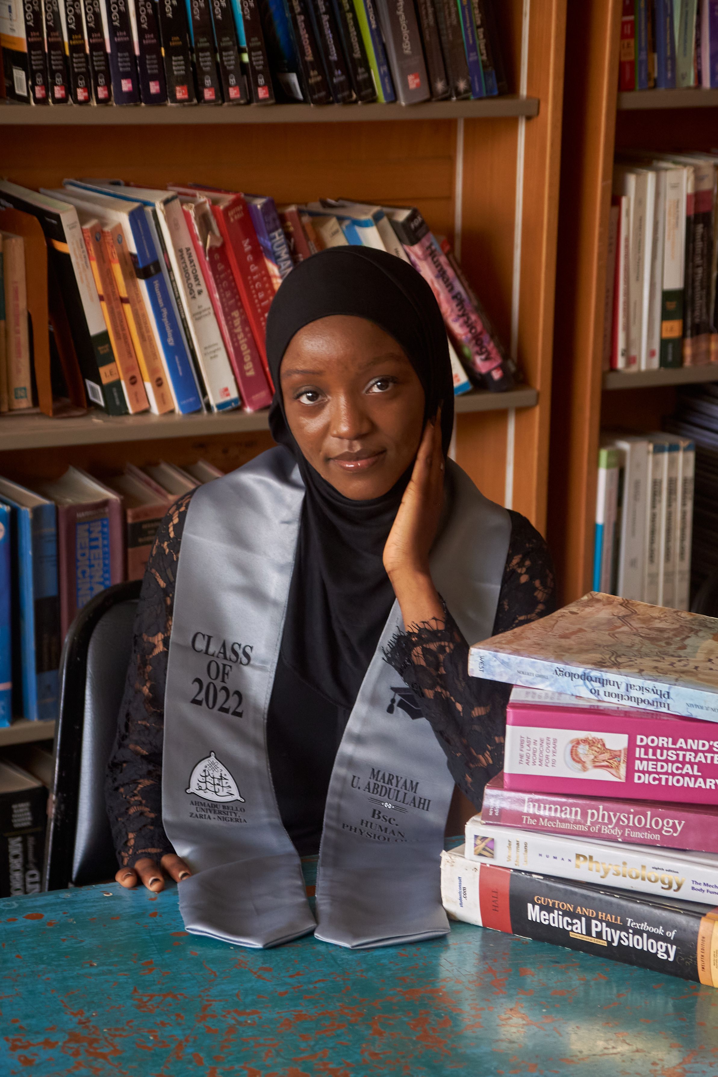 Female Graduate in Library with Books, 2022 · Free Stock Photo