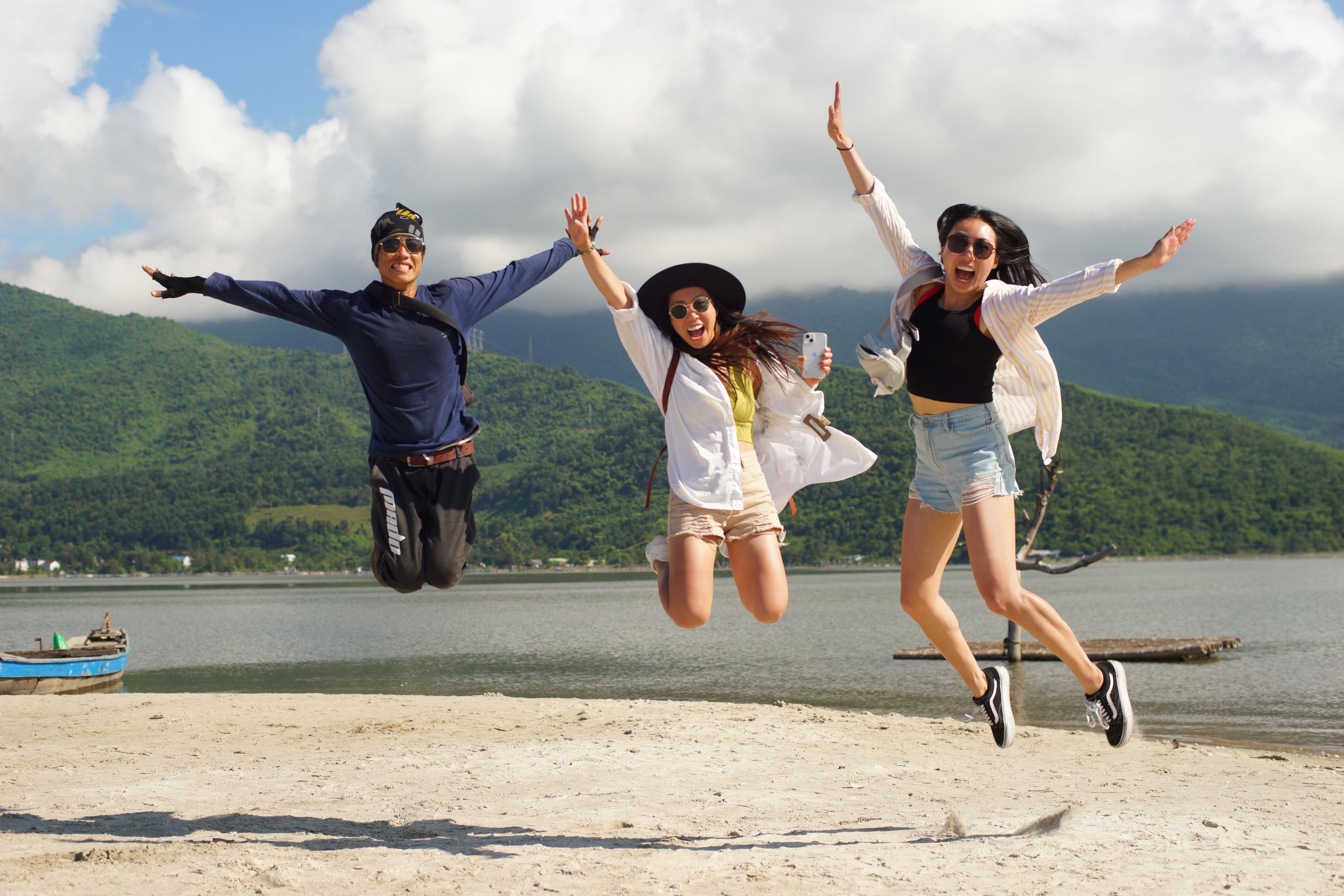Three Friends Jumping on a Beach with Scenic Mountain View · Free Stock ...