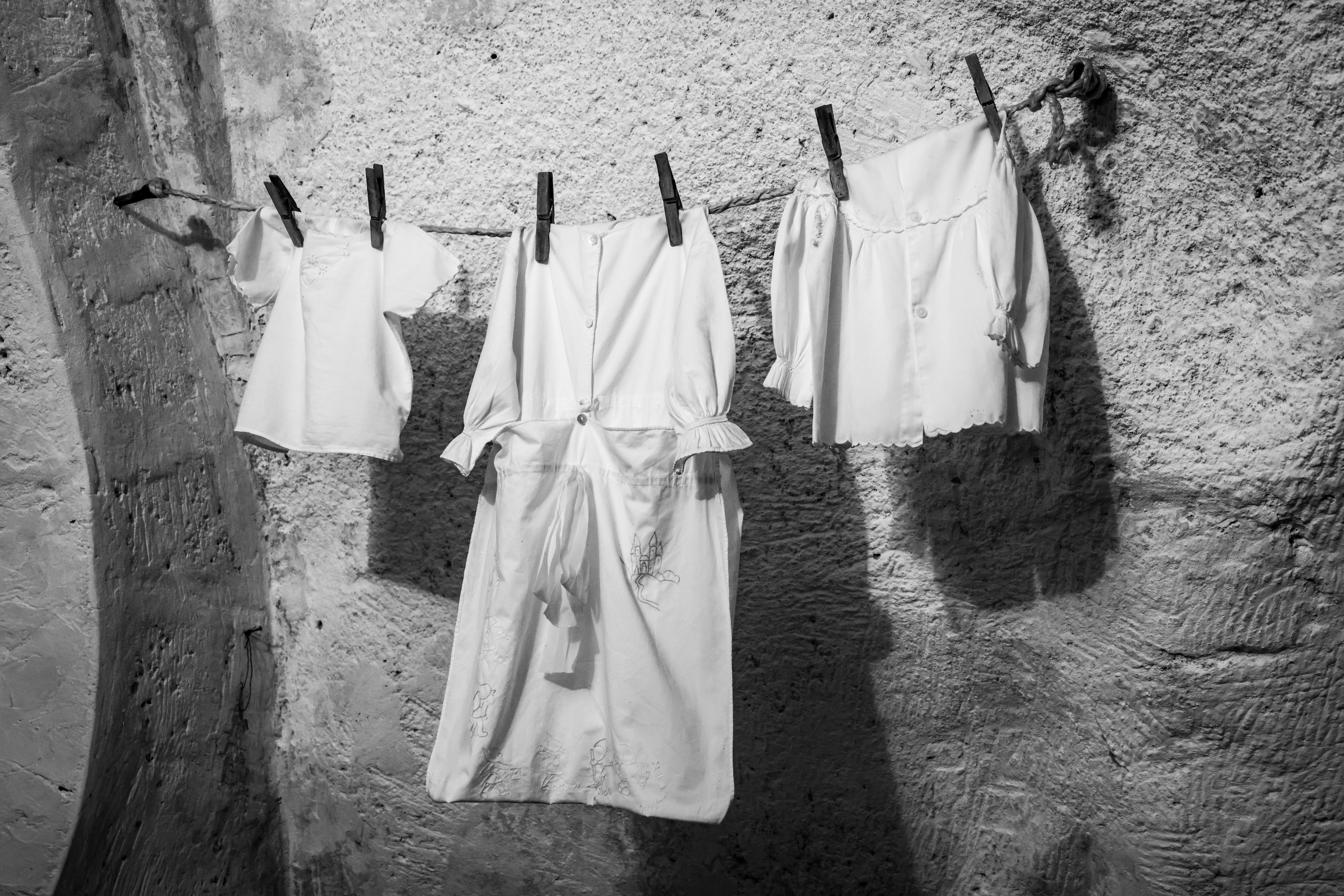 Black and White Hanging Garments in Rustic Setting · Free Stock Photo
