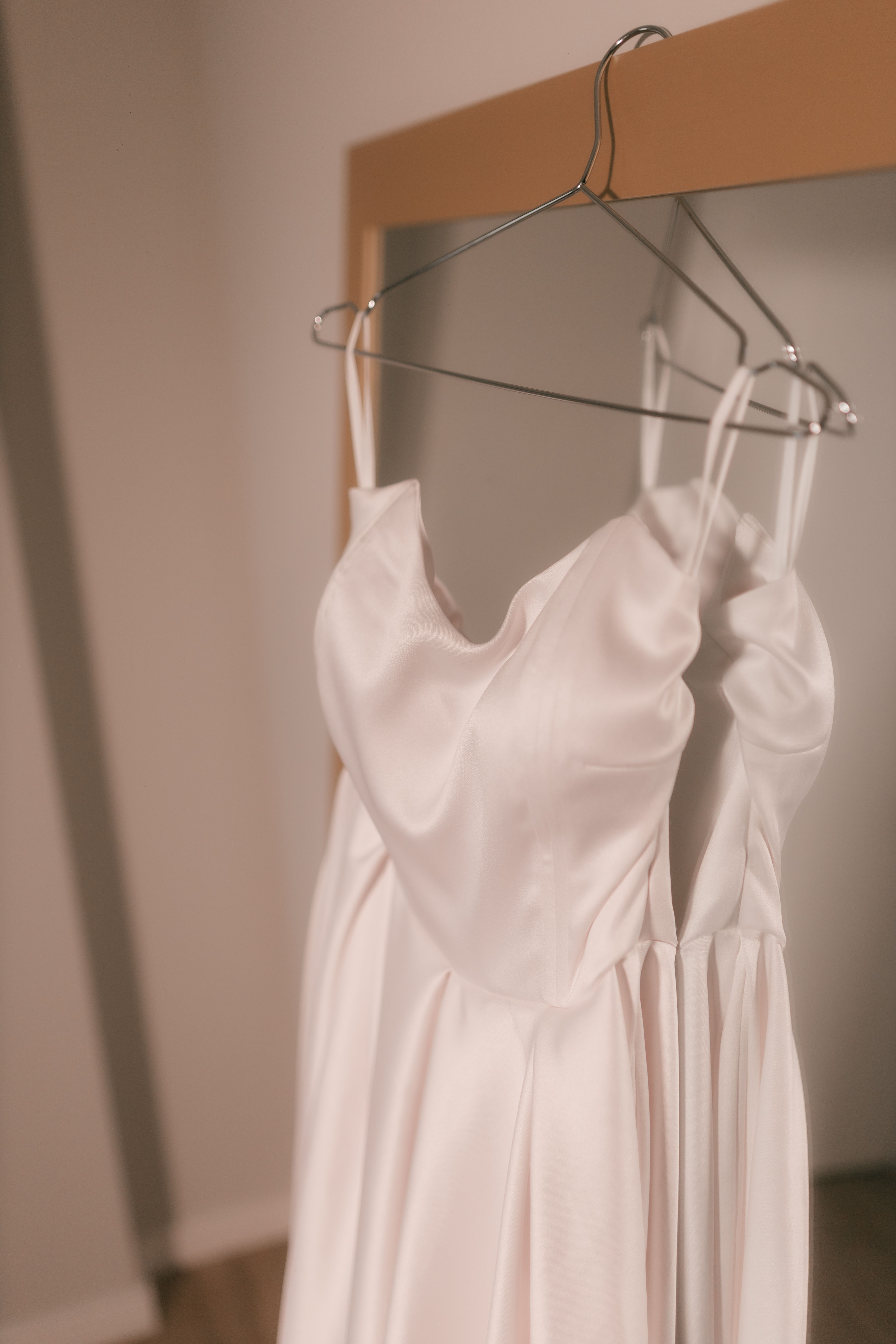 Elegant White Satin Dress Hanging on a Hanger · Free Stock Photo