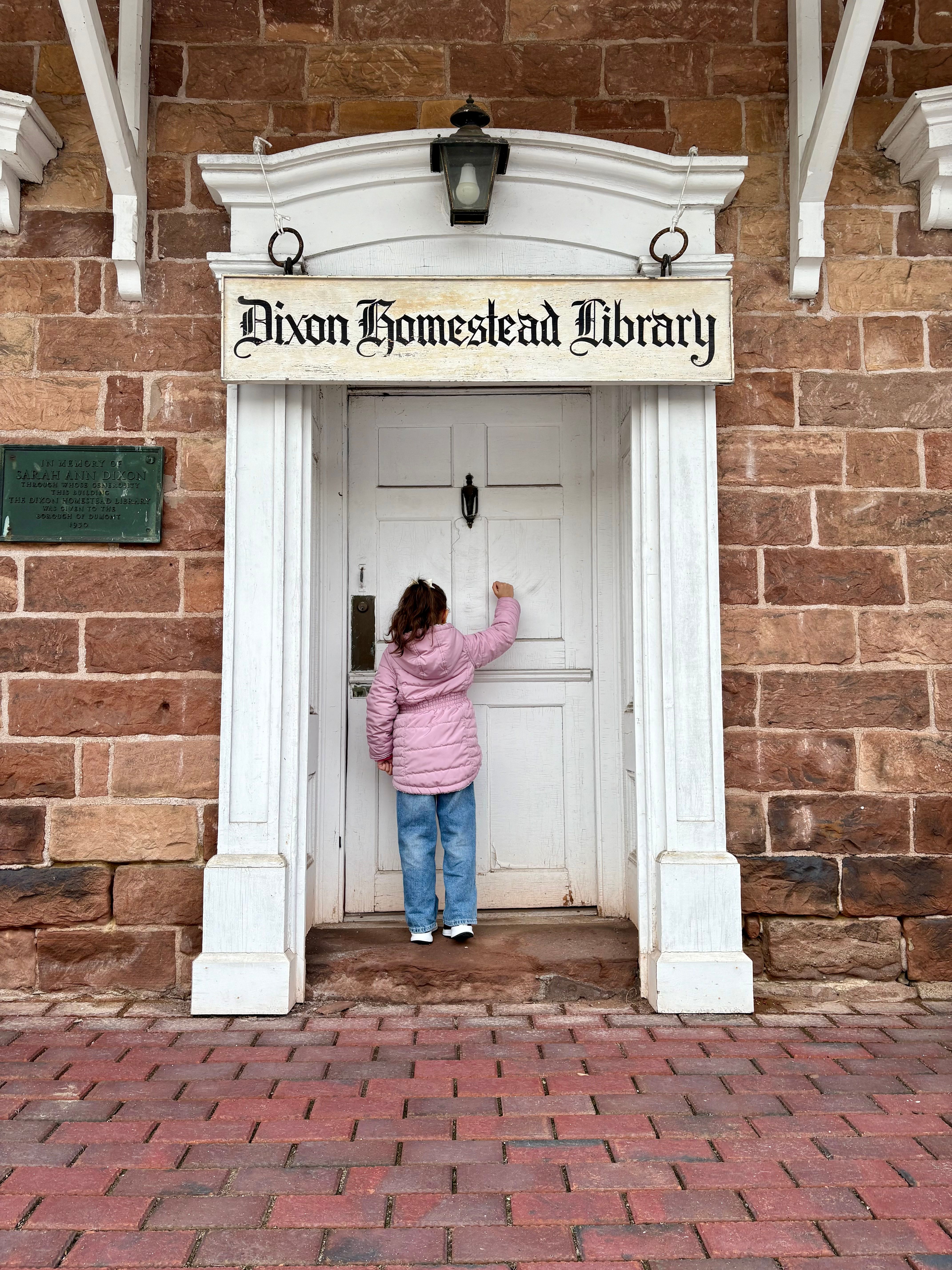 Child Knocking at Historic Library Door in Dumont · Free Stock Photo