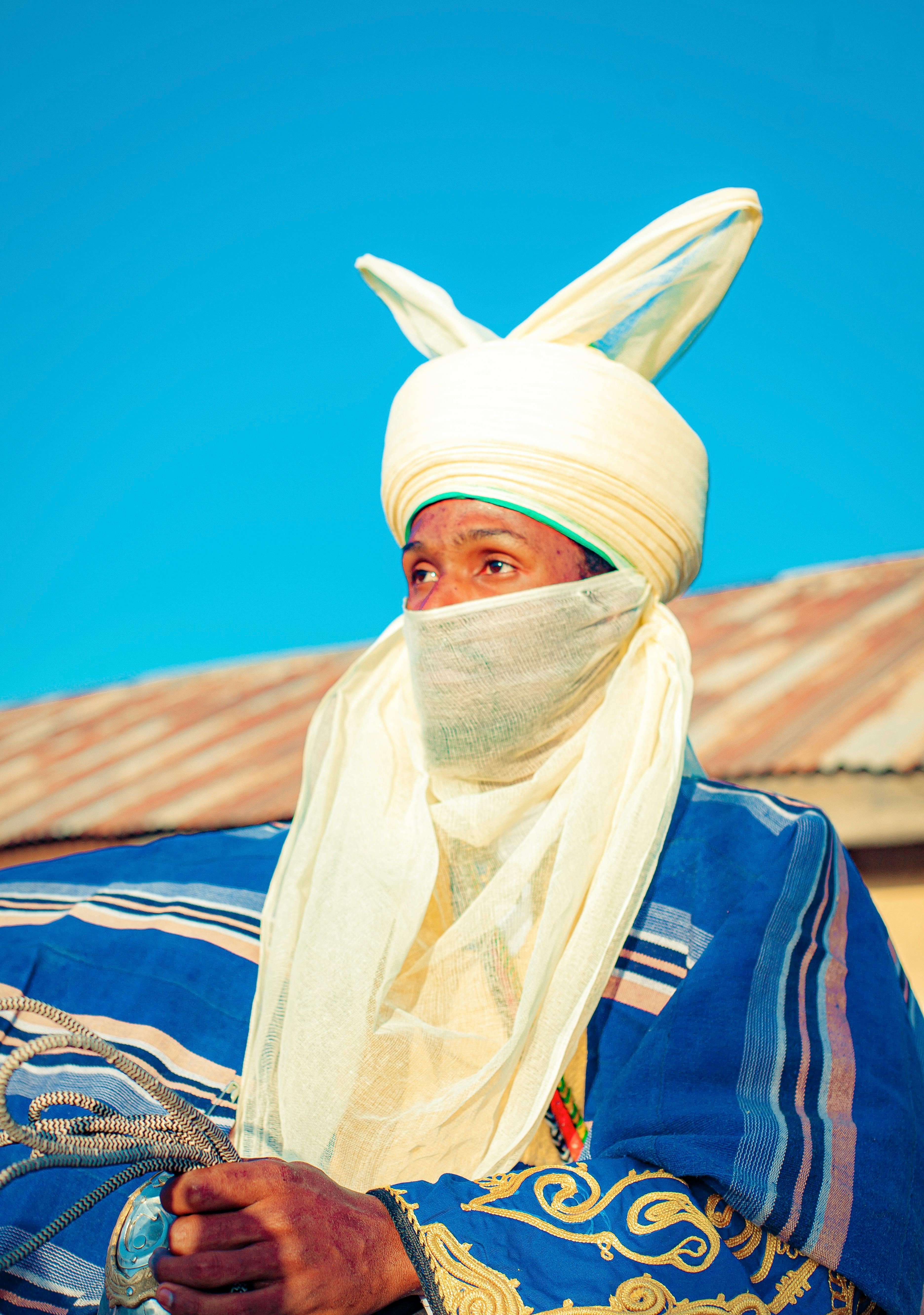 Traditional Hausa Attire Against Blue Sky · Free Stock Photo